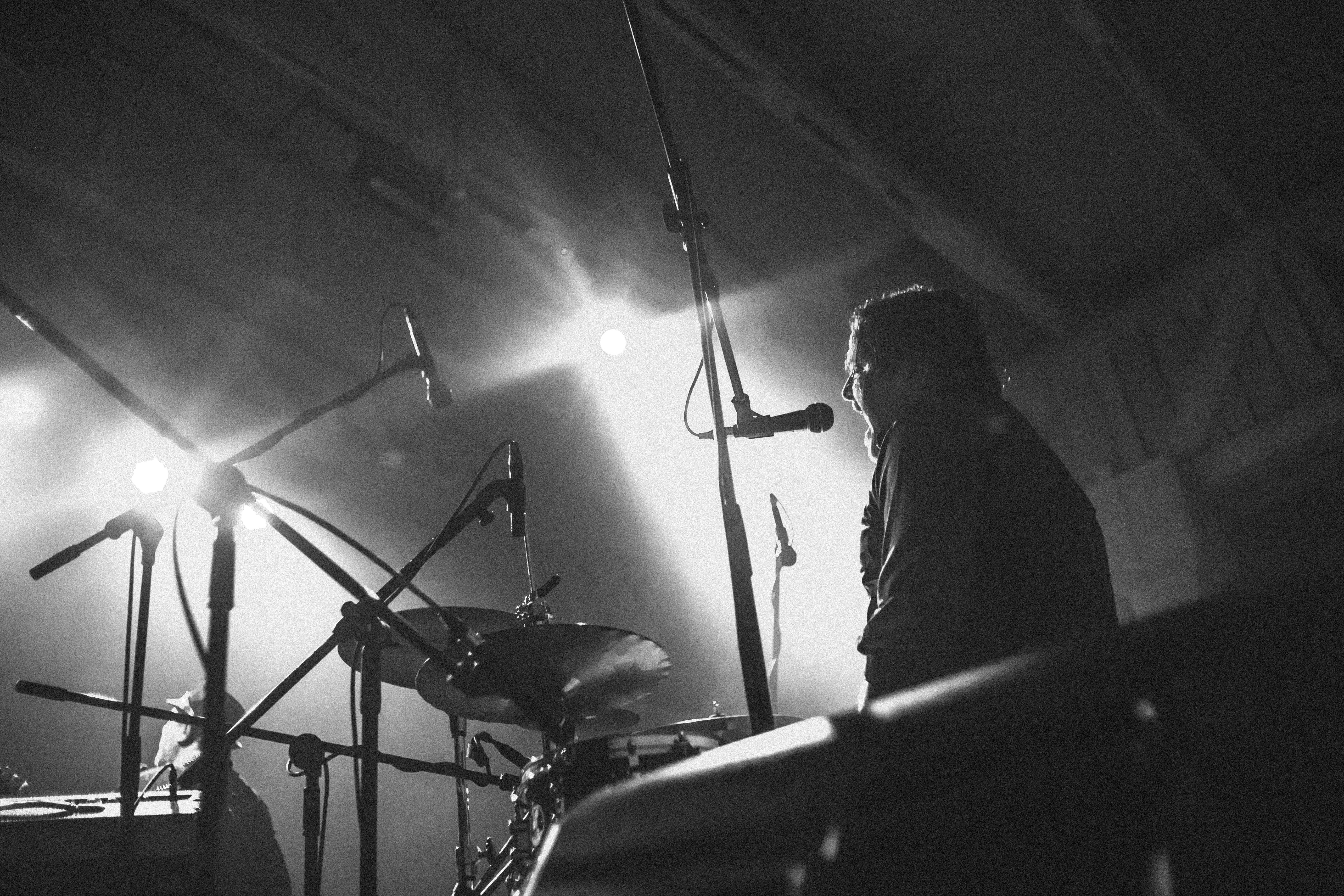 A man standing in front of a drum set photo – Free Concert Image on ...