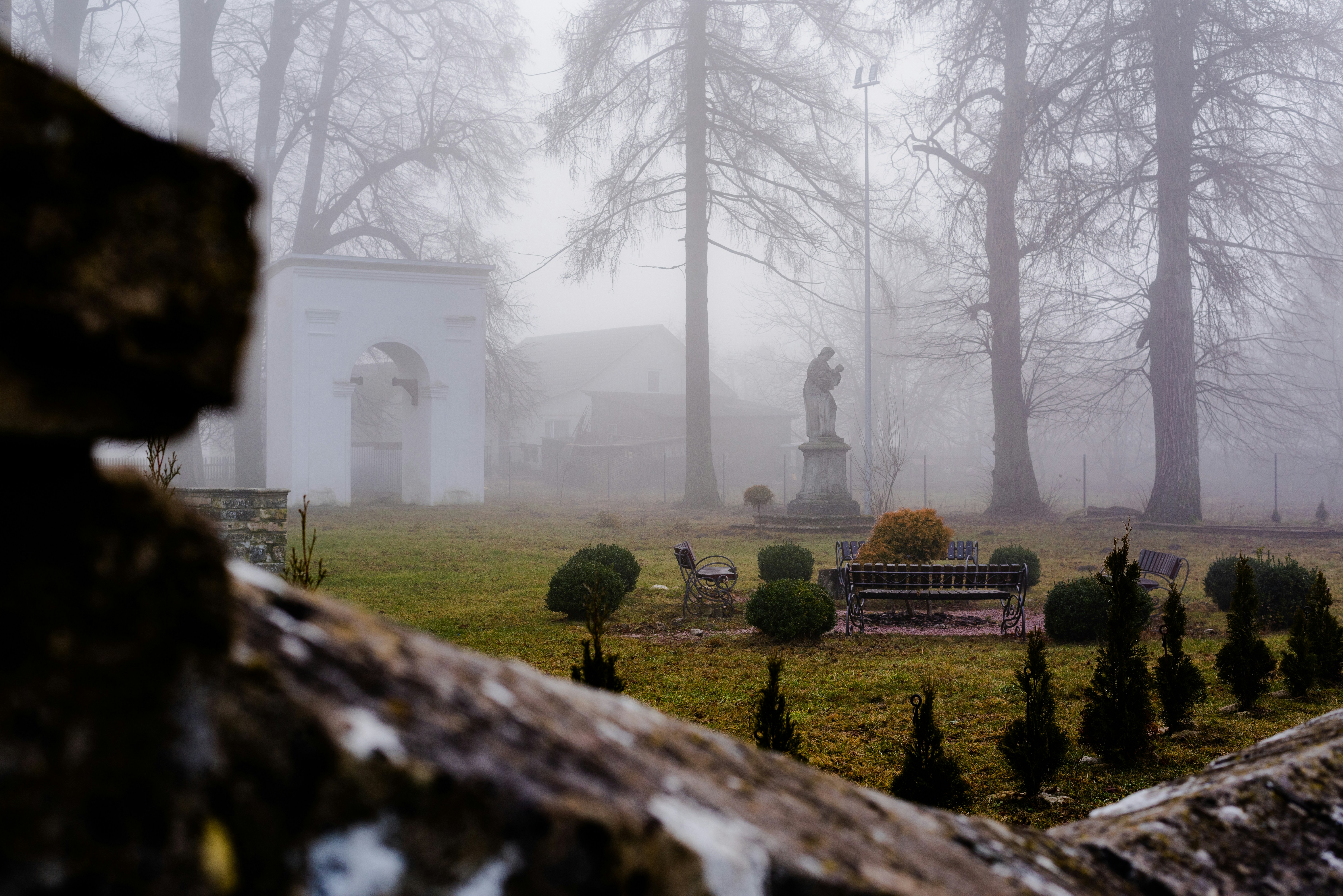 Mist Shrouded Garden with Statues and Archway
