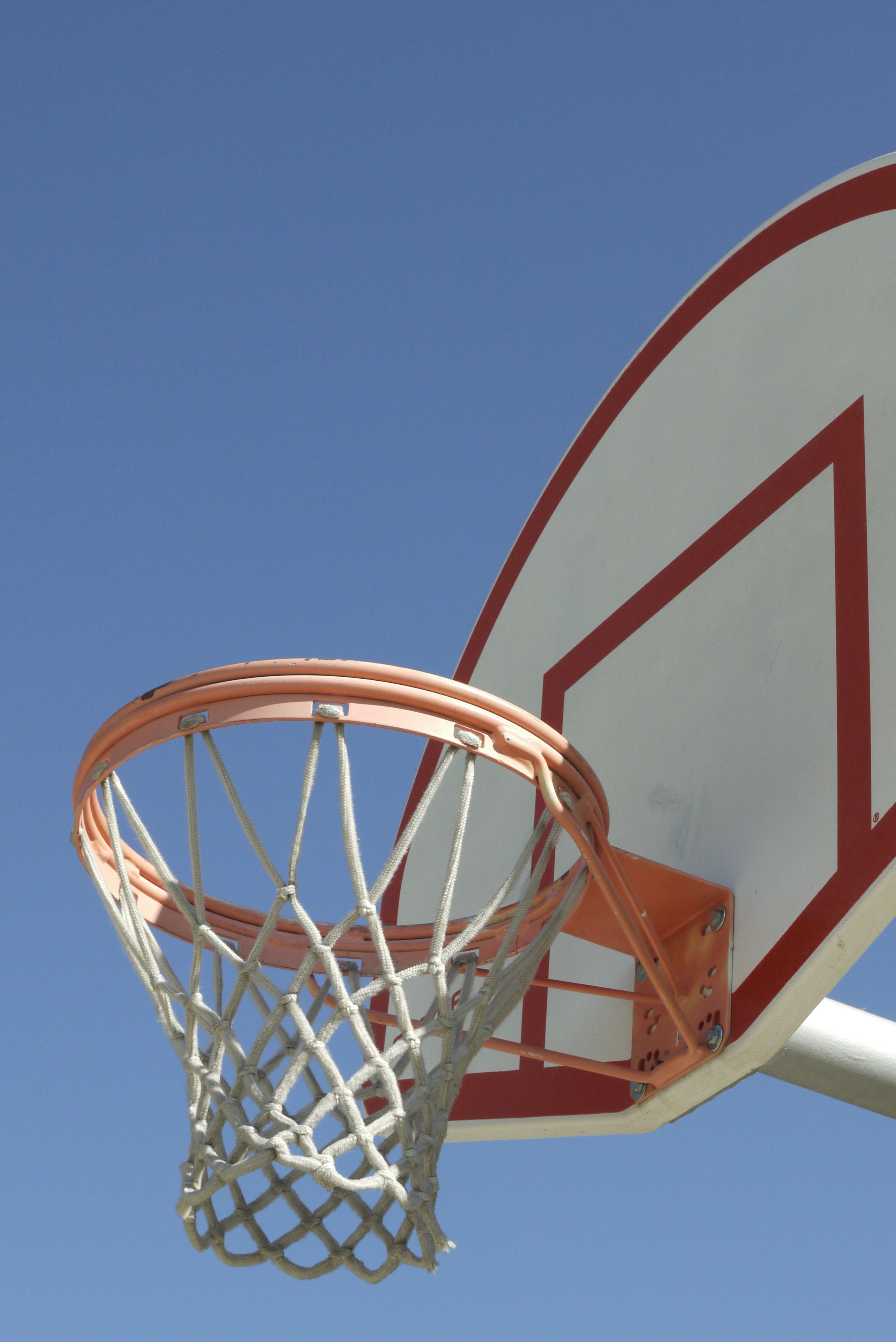 A basketball going through the rim of a basketball hoop photo – Free ...