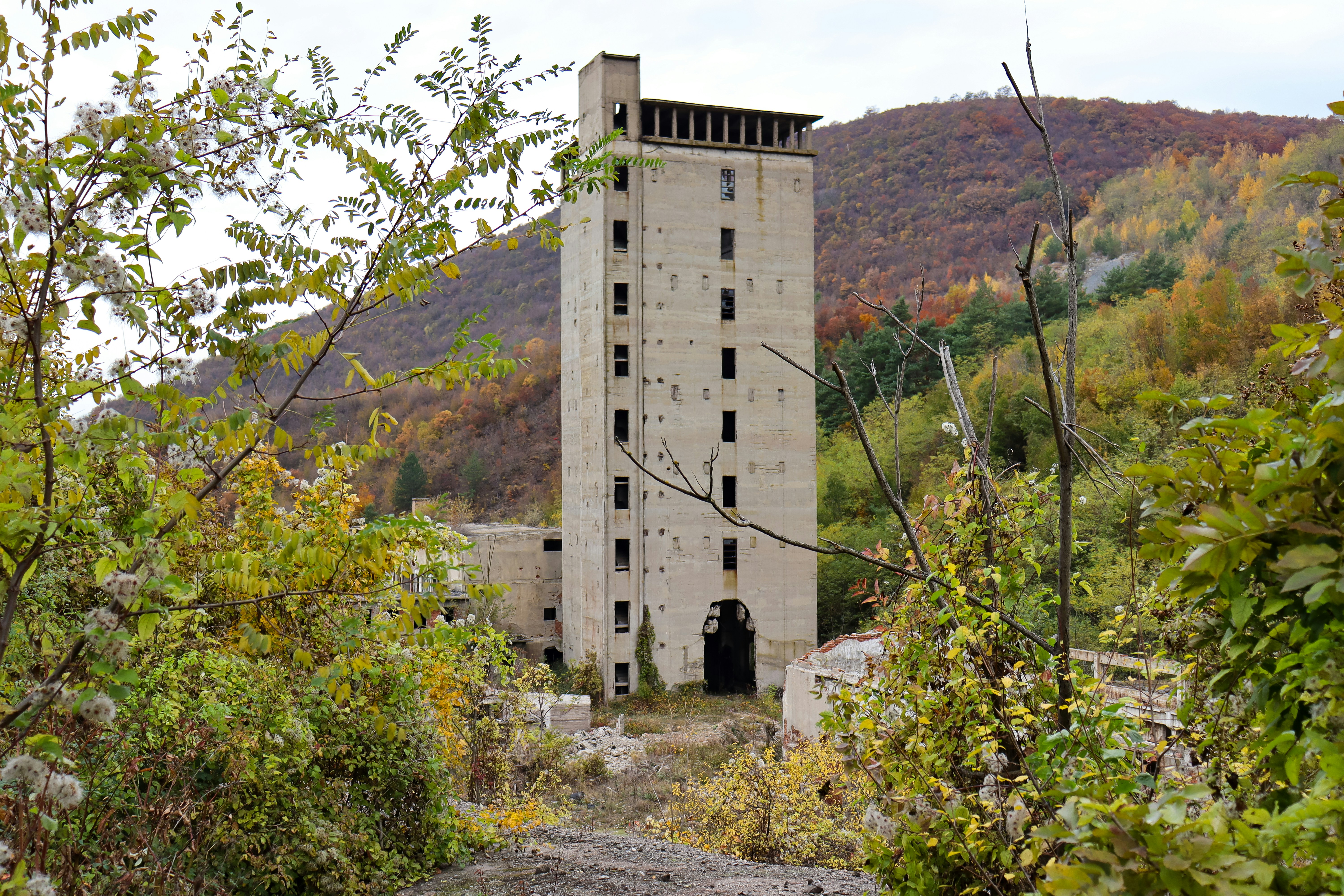 Towering Echoes: An AbandonedStructure Nestled Between Autumn Hills