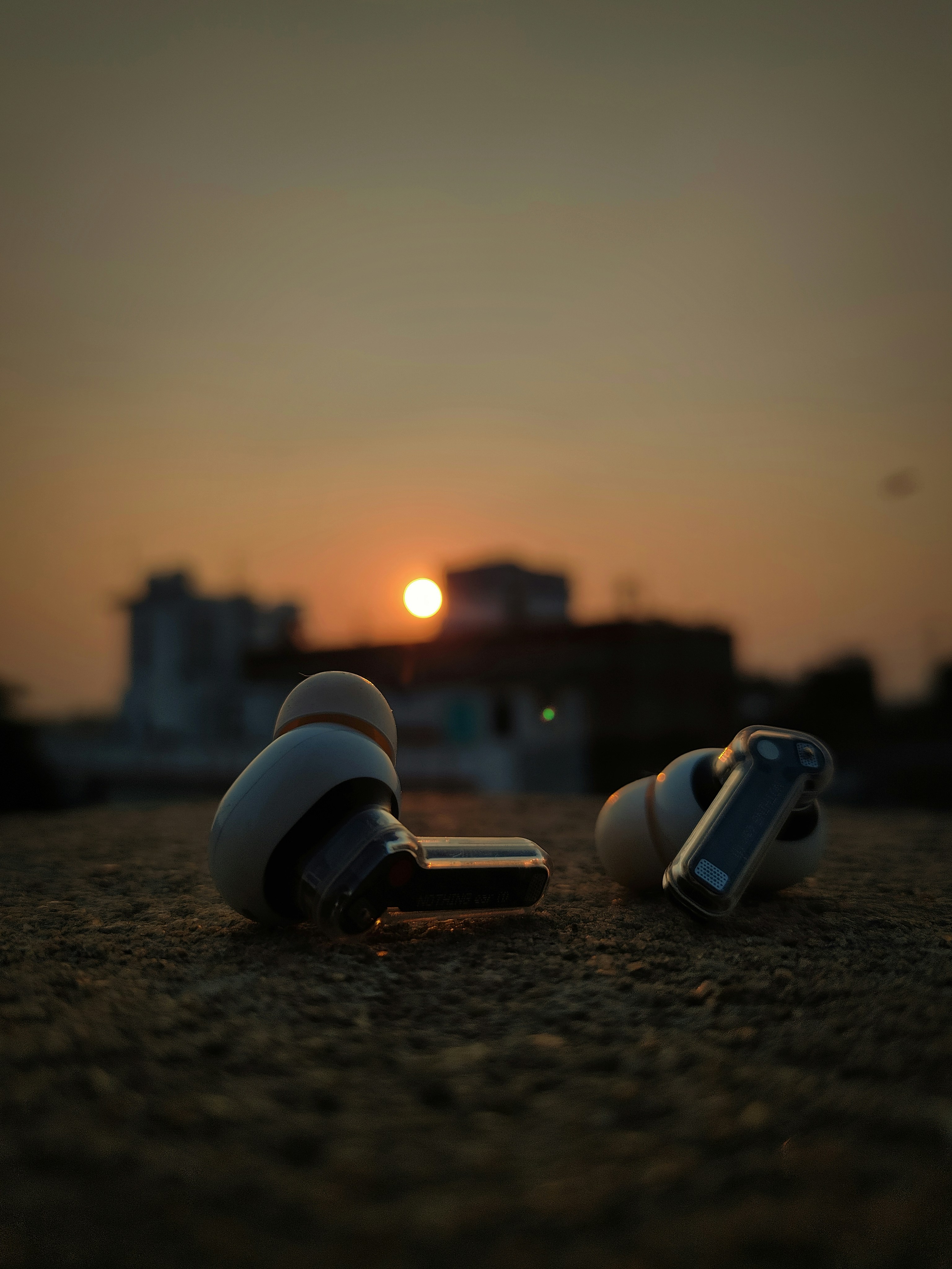 A couple of ear buds sitting on top of a sandy ground photo – Free Sky ...