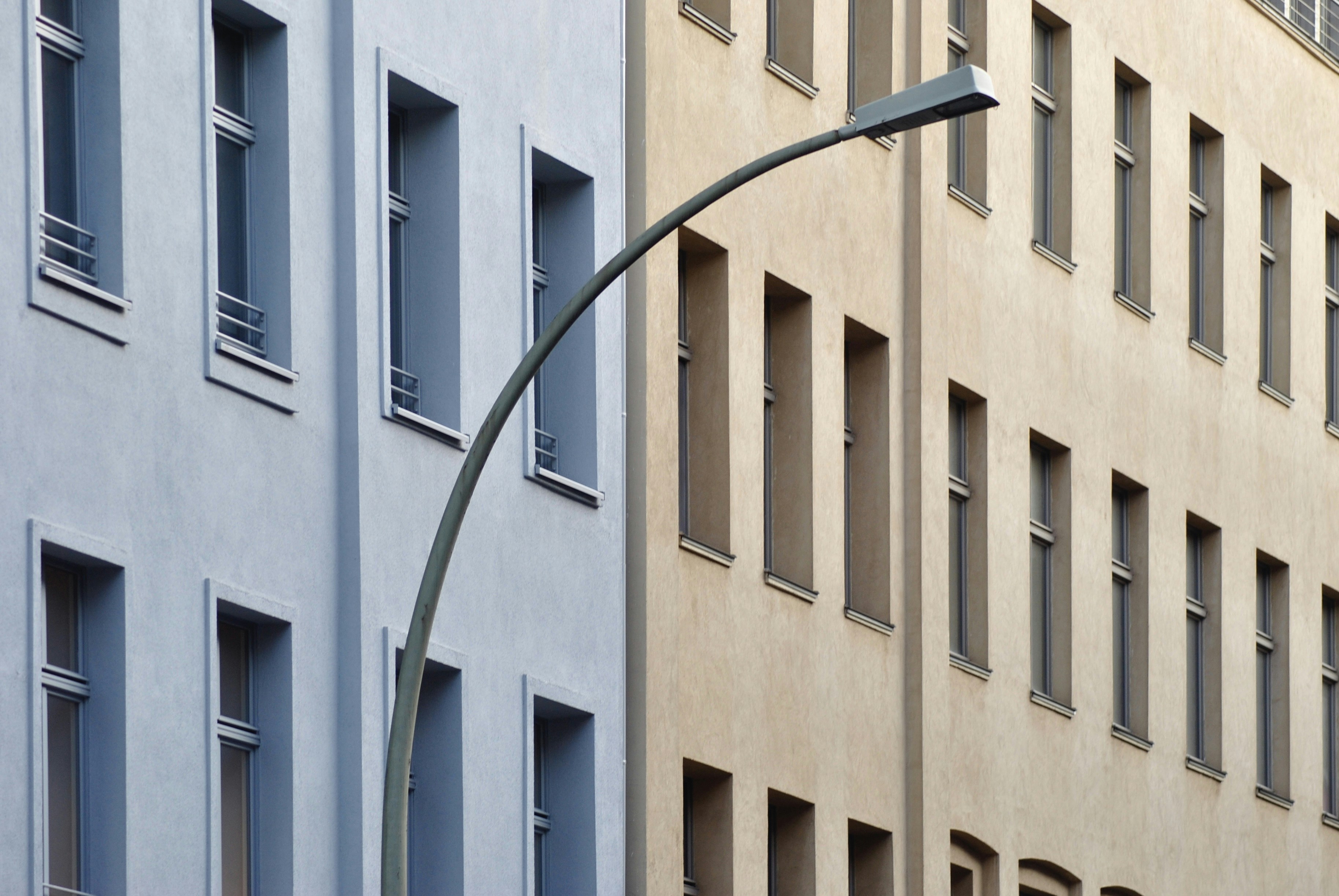 Arched Streetlamp Over a Duotone City Facade
