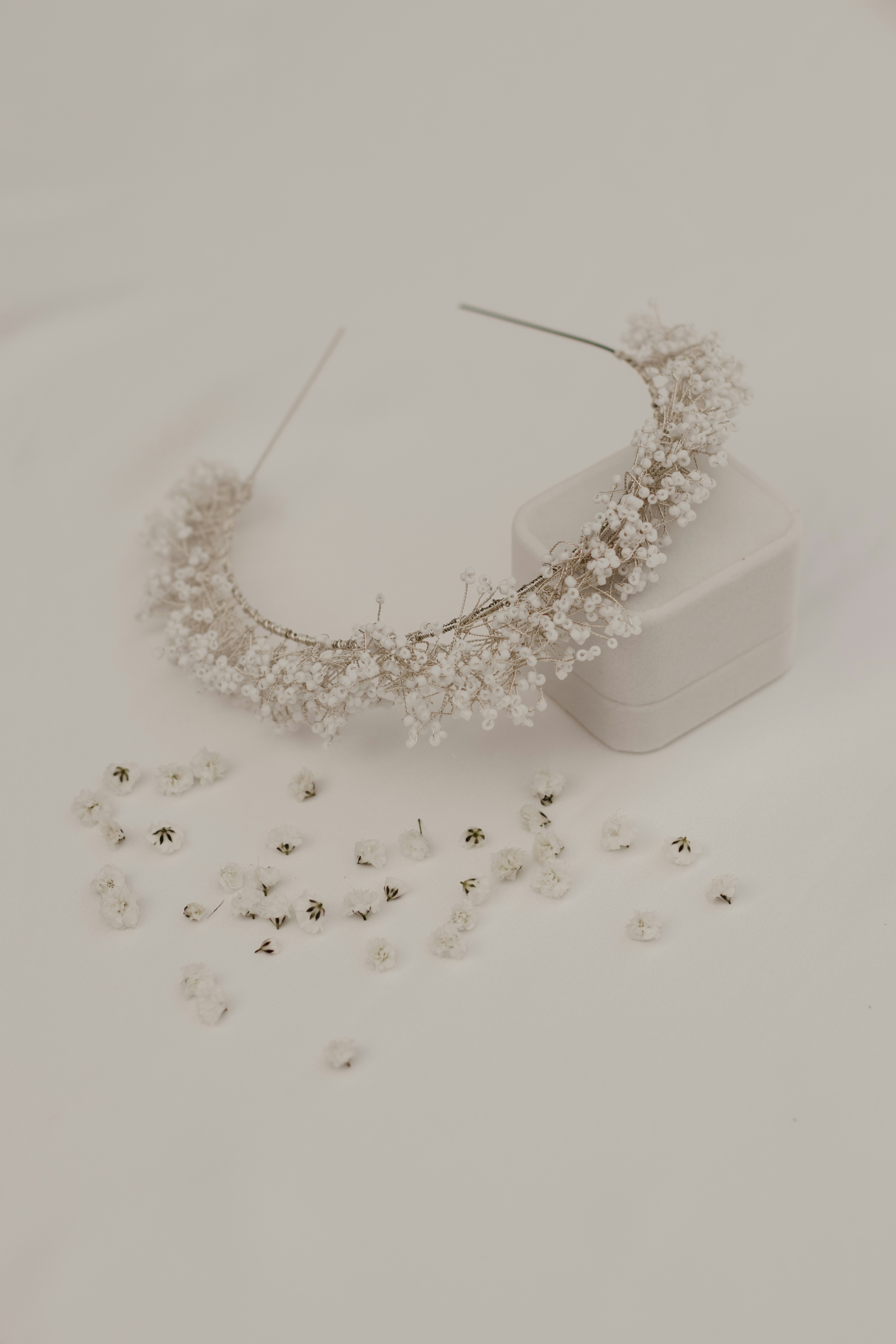 Delicate bridal floral crown resting atop a white jewelry box in a quiet studio still-life