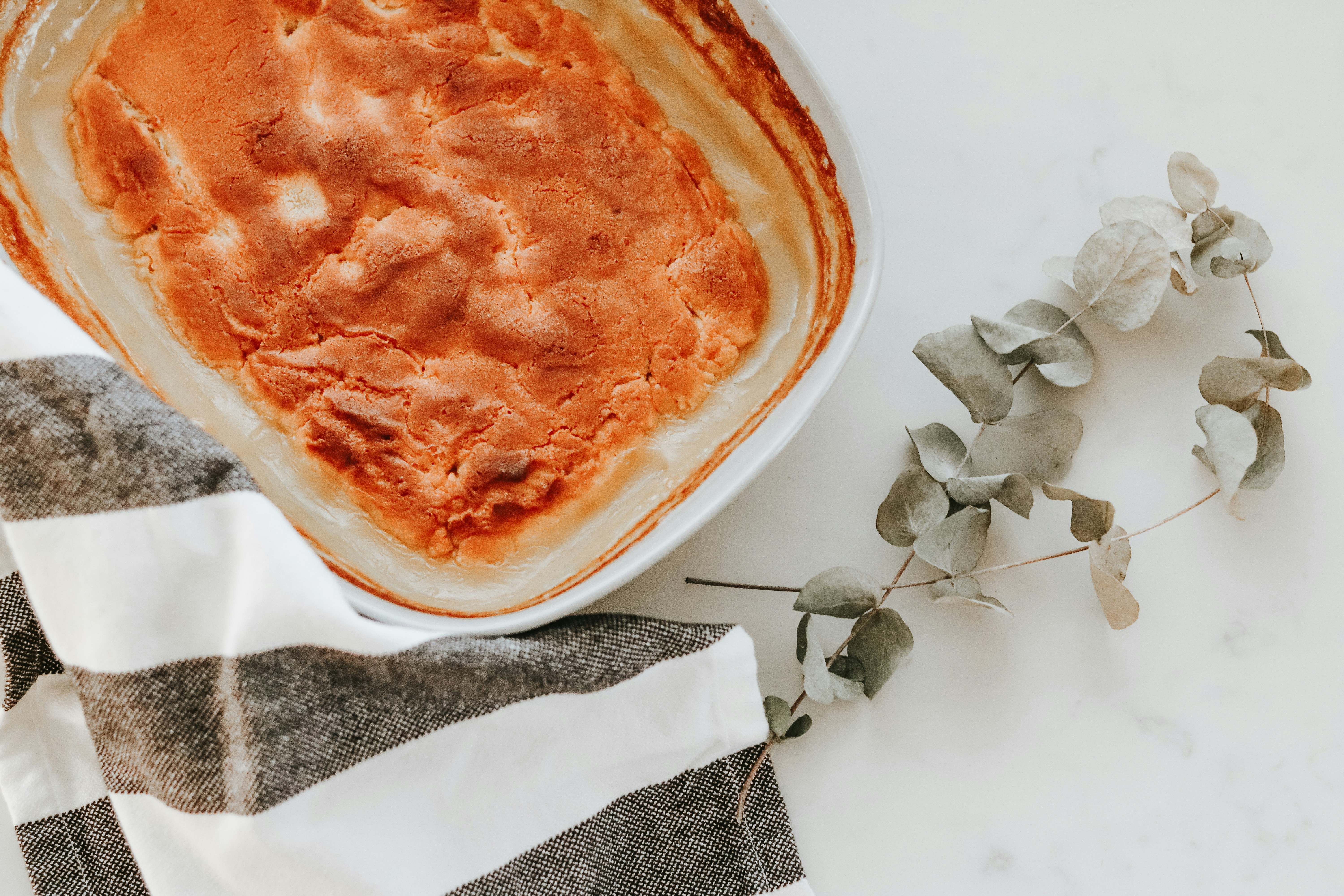 Top-Down Comfort Bake: A Creamy Casserole Framed by Linen and Eucalyptus