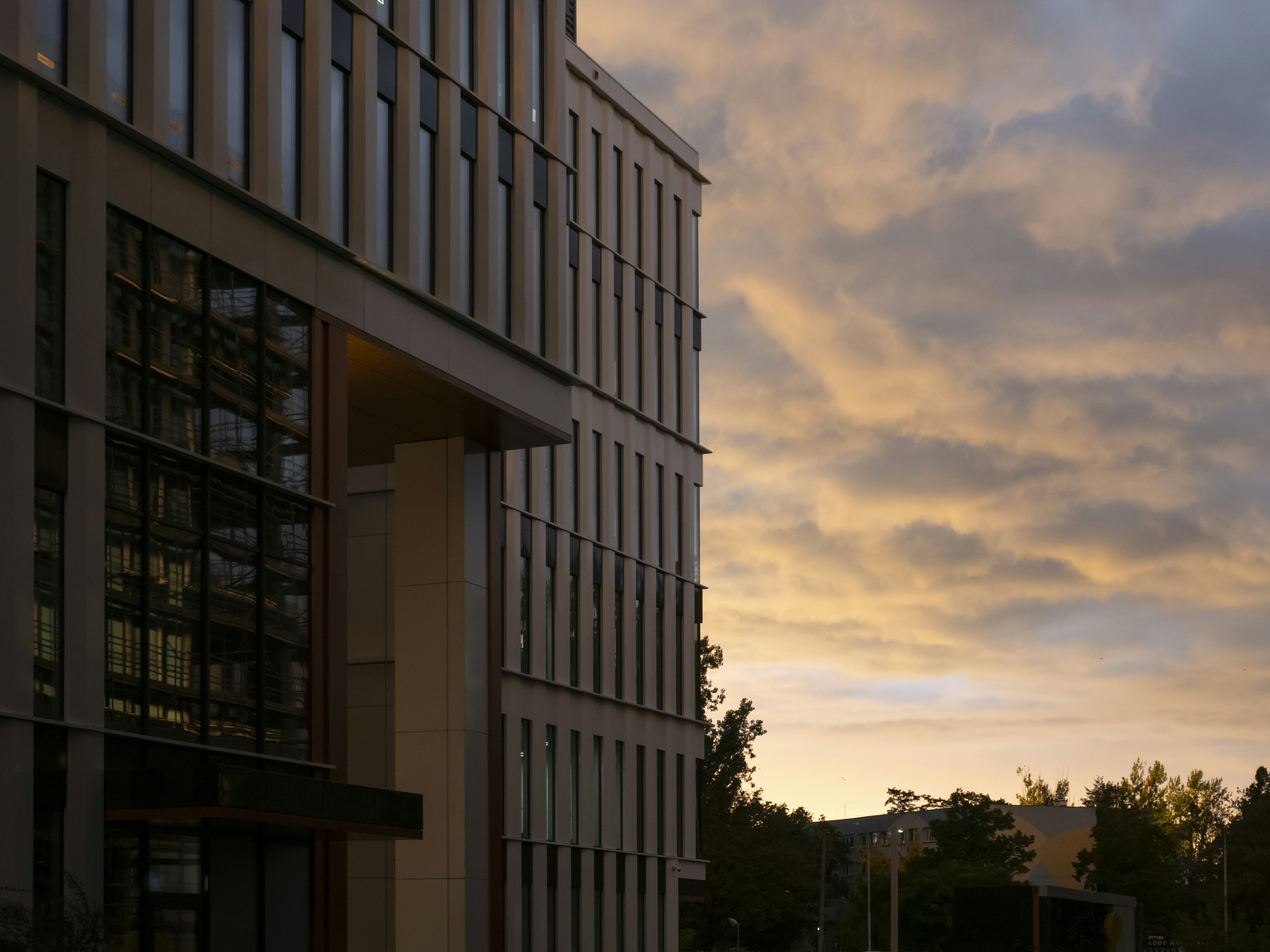 Modern office and residential buildings in the evening city, Wroclaw, Poland | a very tall building sitting next to a tall building