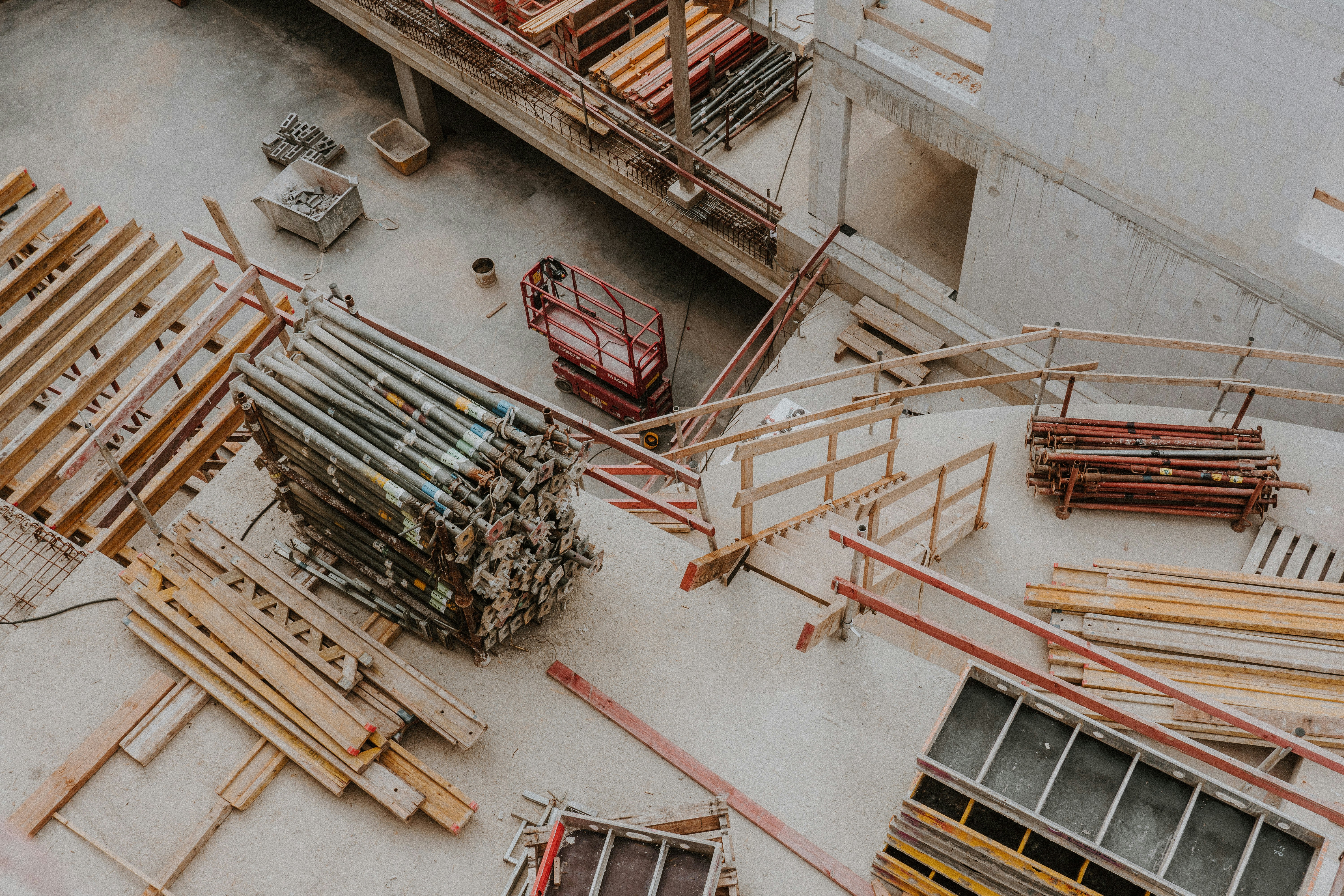 A large group of wooden beams sitting on top of a cement floor photo ...
