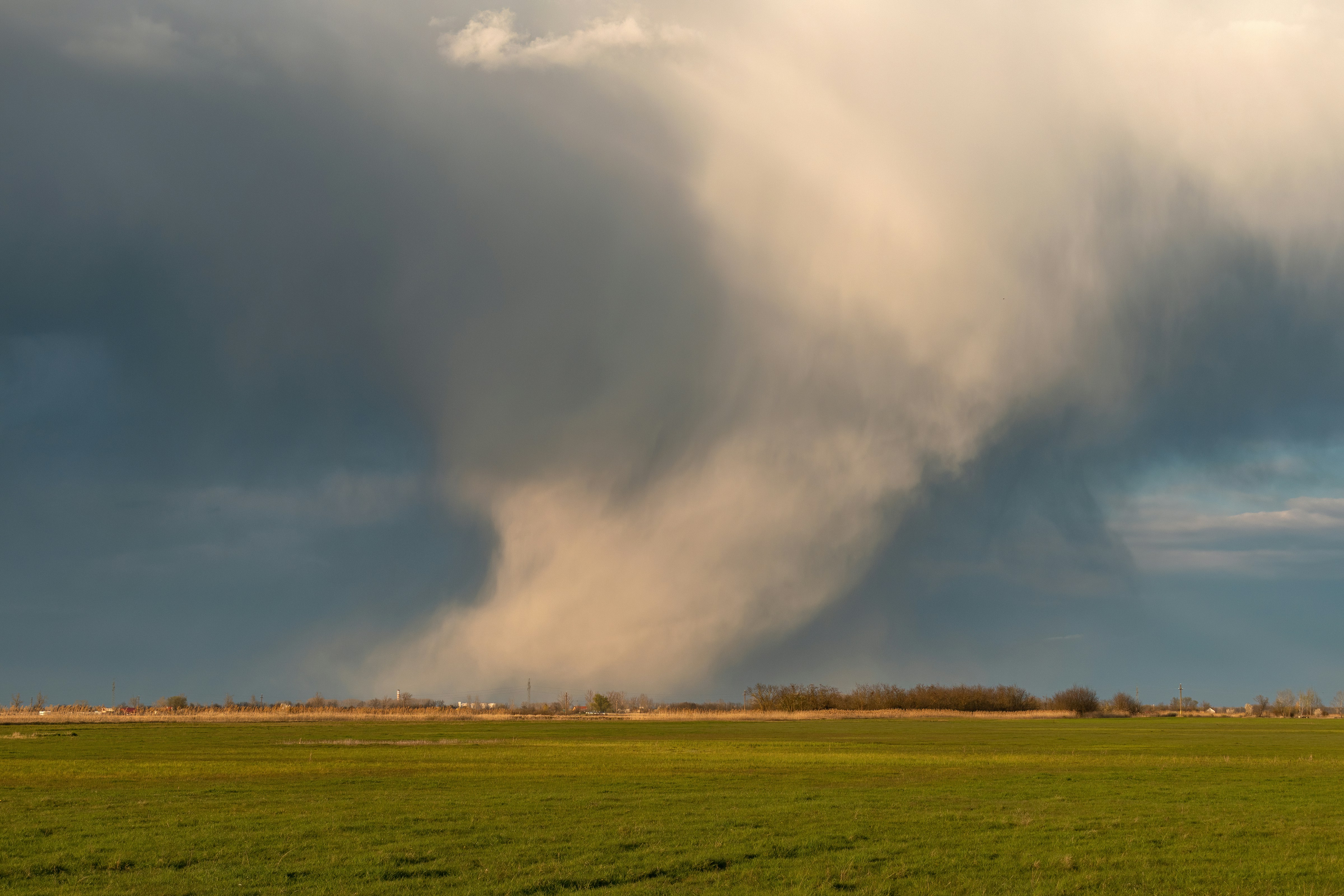 A large storm cloud looms over a green field photo – Free Scenery Image ...