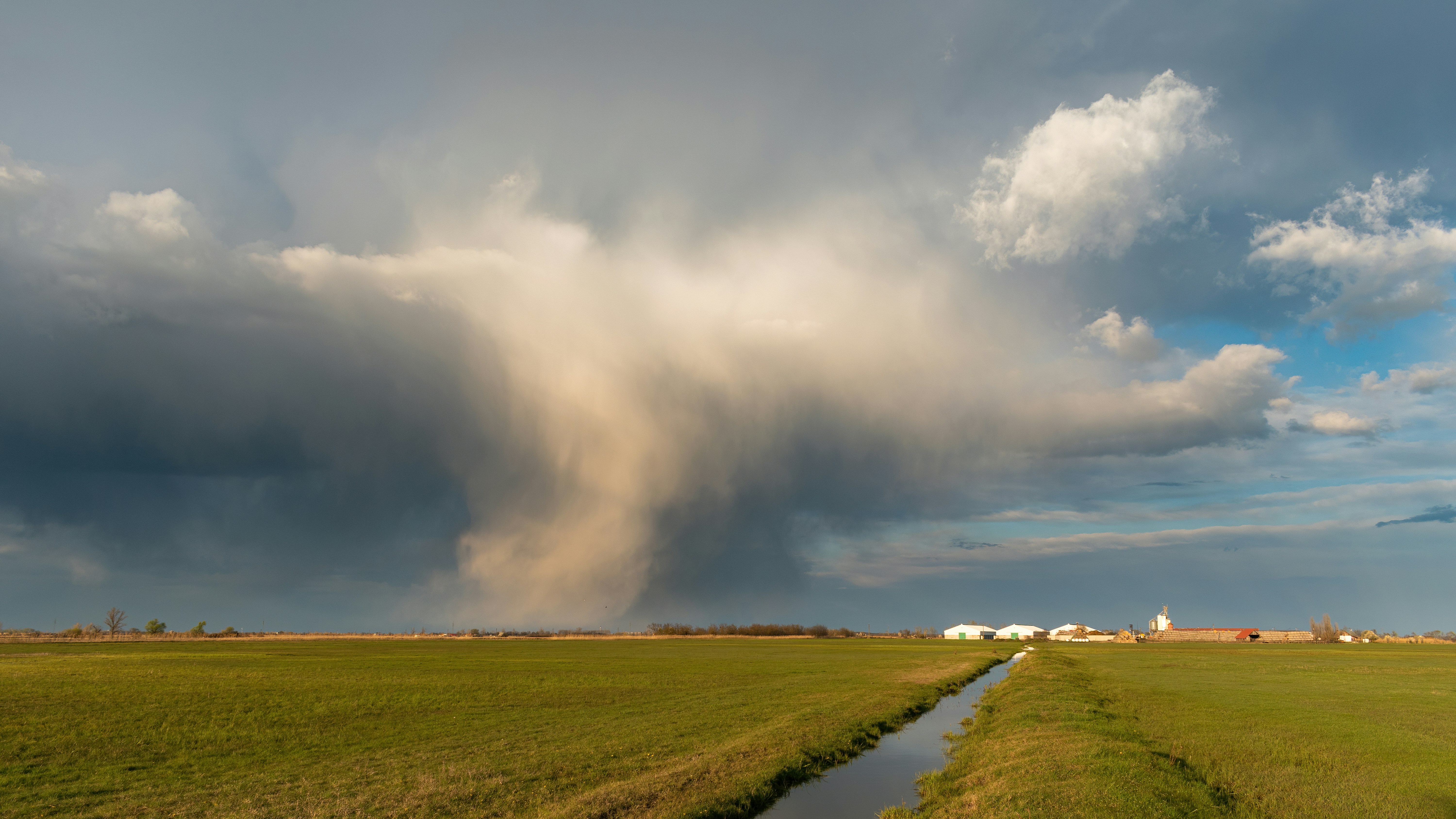 A large storm cloud looms over a green field photo – Free Snow fall ...