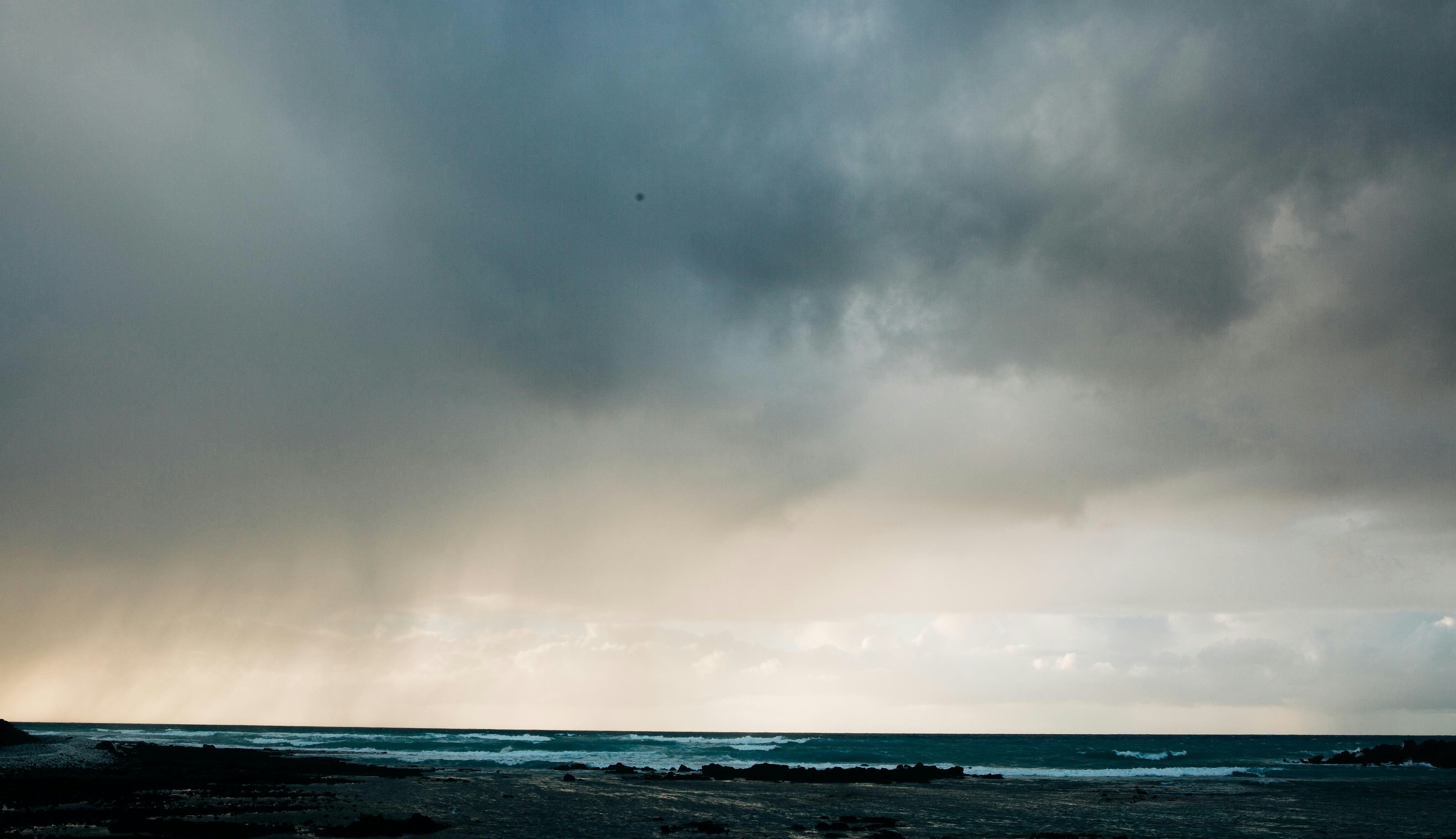 A large storm moving across the sky over the ocean photo – Free Cloud ...