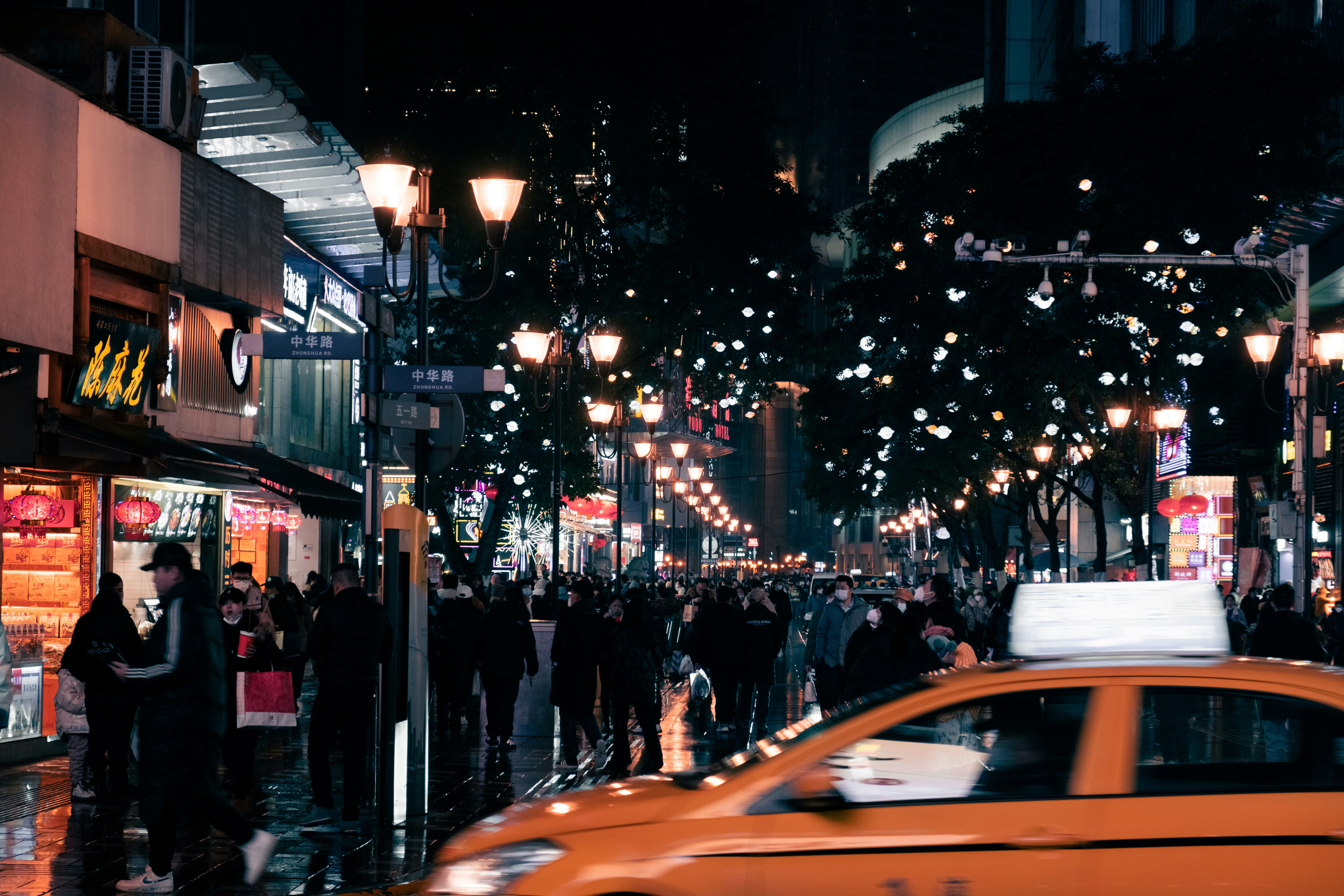 Night Pulse on a Bustling Street: Neon, Pedestrians and a Blurred Taxi