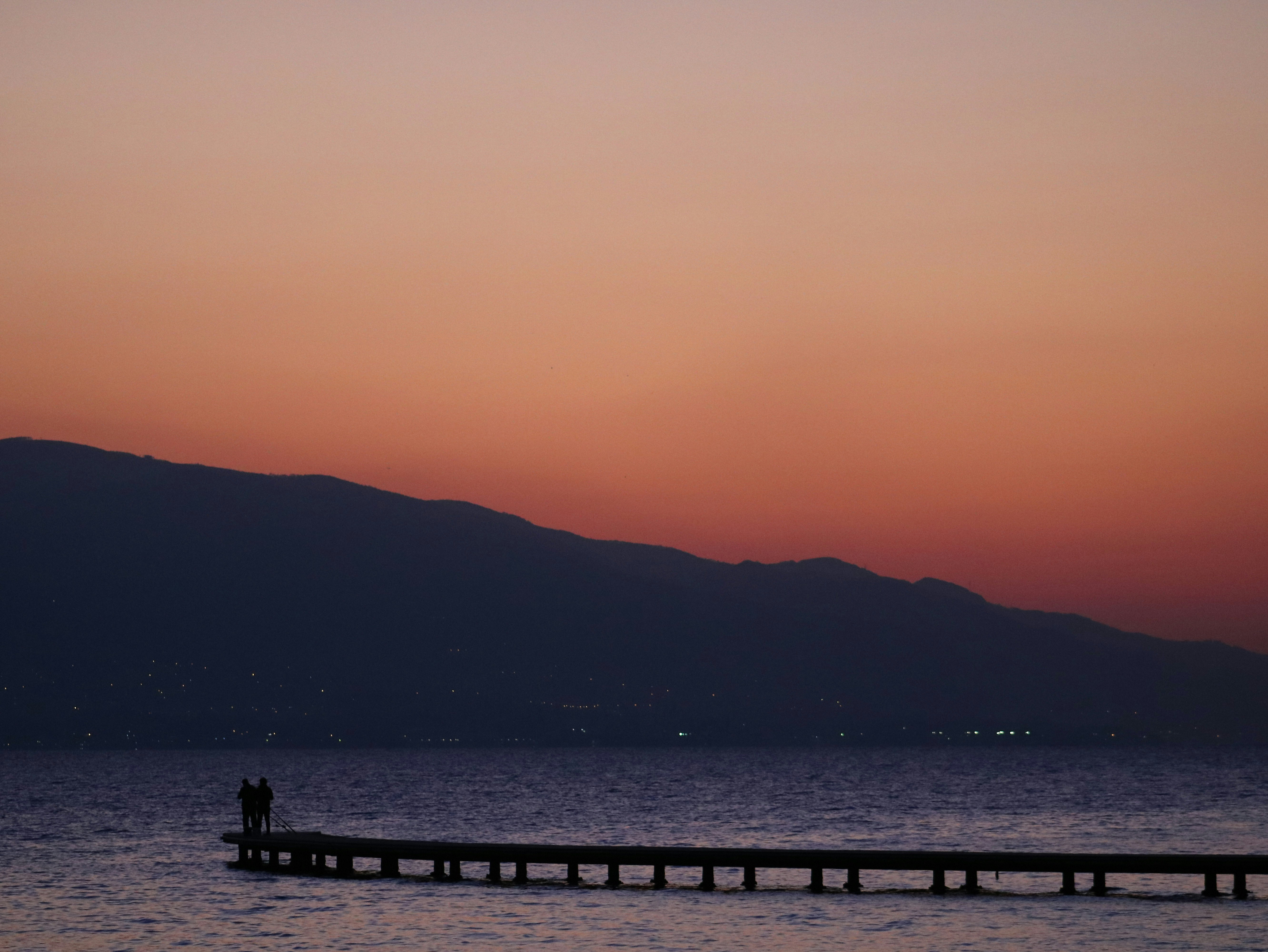 a couple of people standing on top of a pier