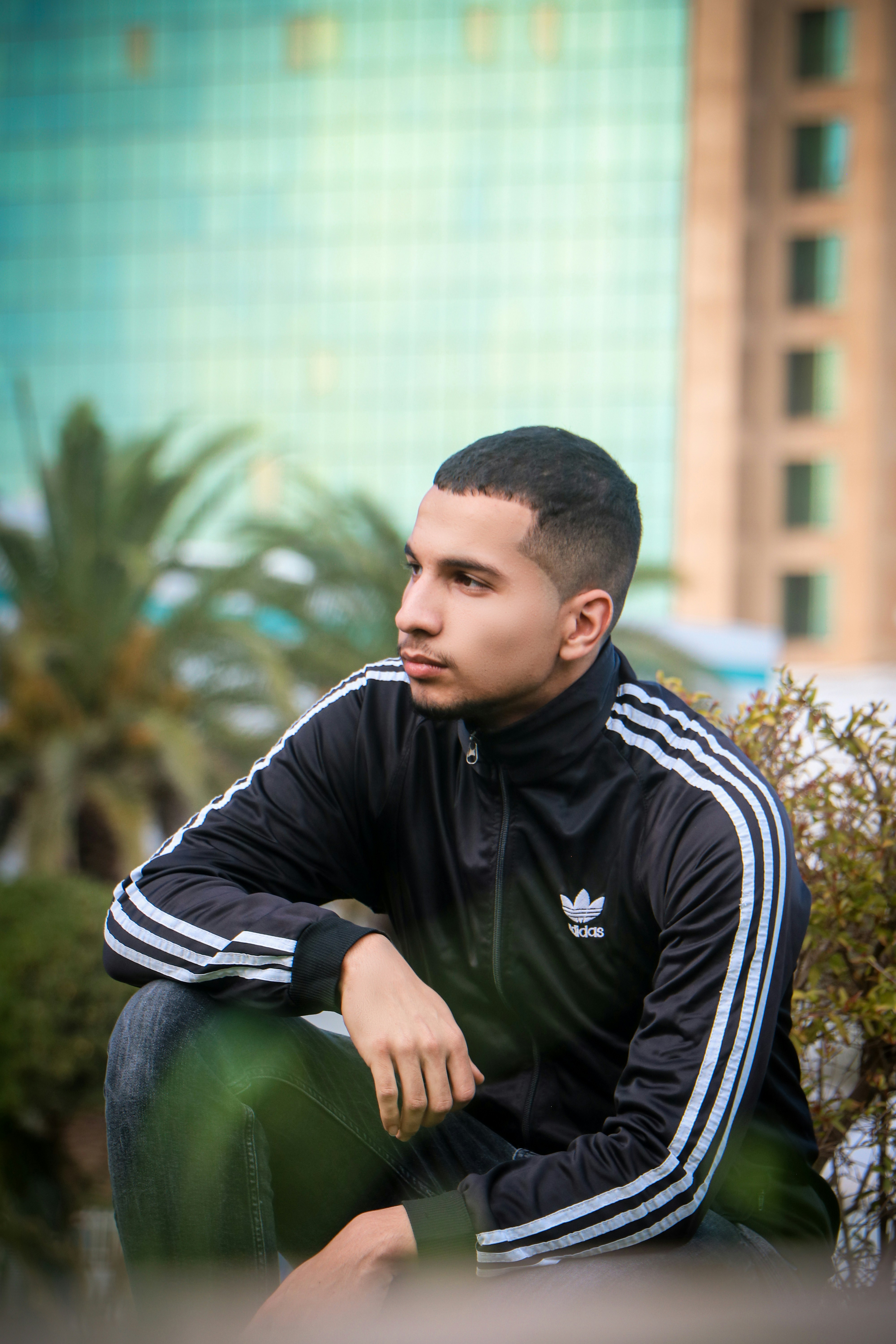 Contemplative Portrait Against a Turquoise Glass Skyline