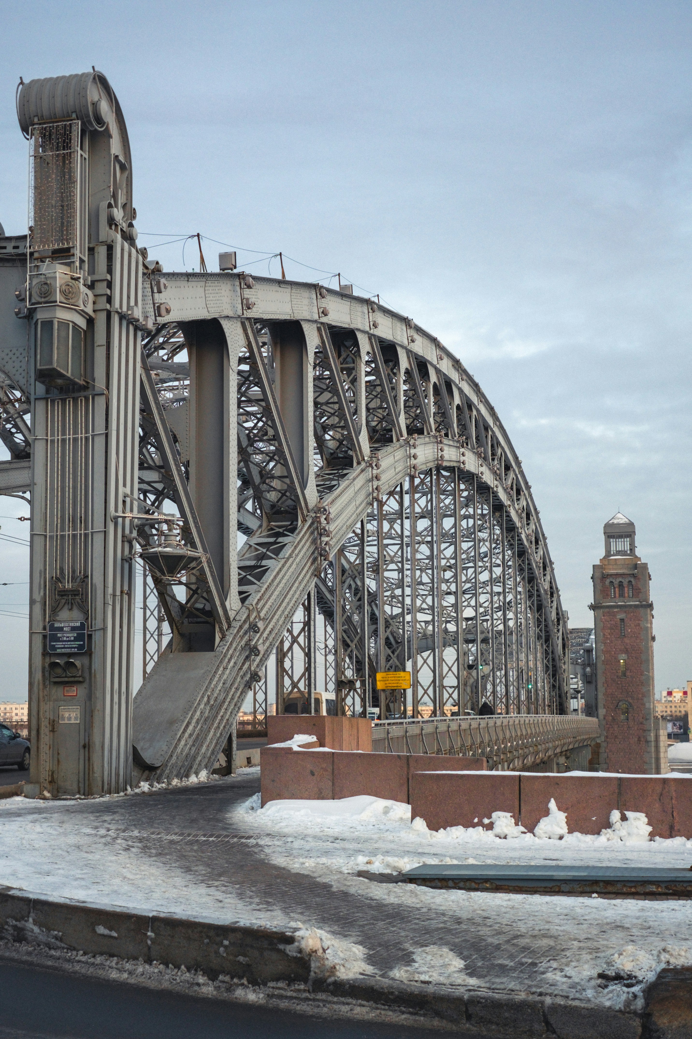 A large metal bridge over a street next to a tall building photo – Free ...