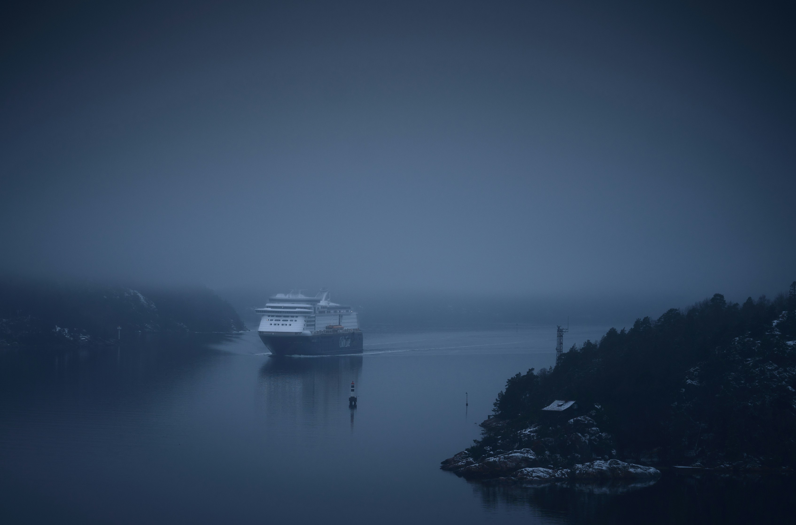 Blue Veil over the Fjord: A Quiet Vessel in Dense Fog