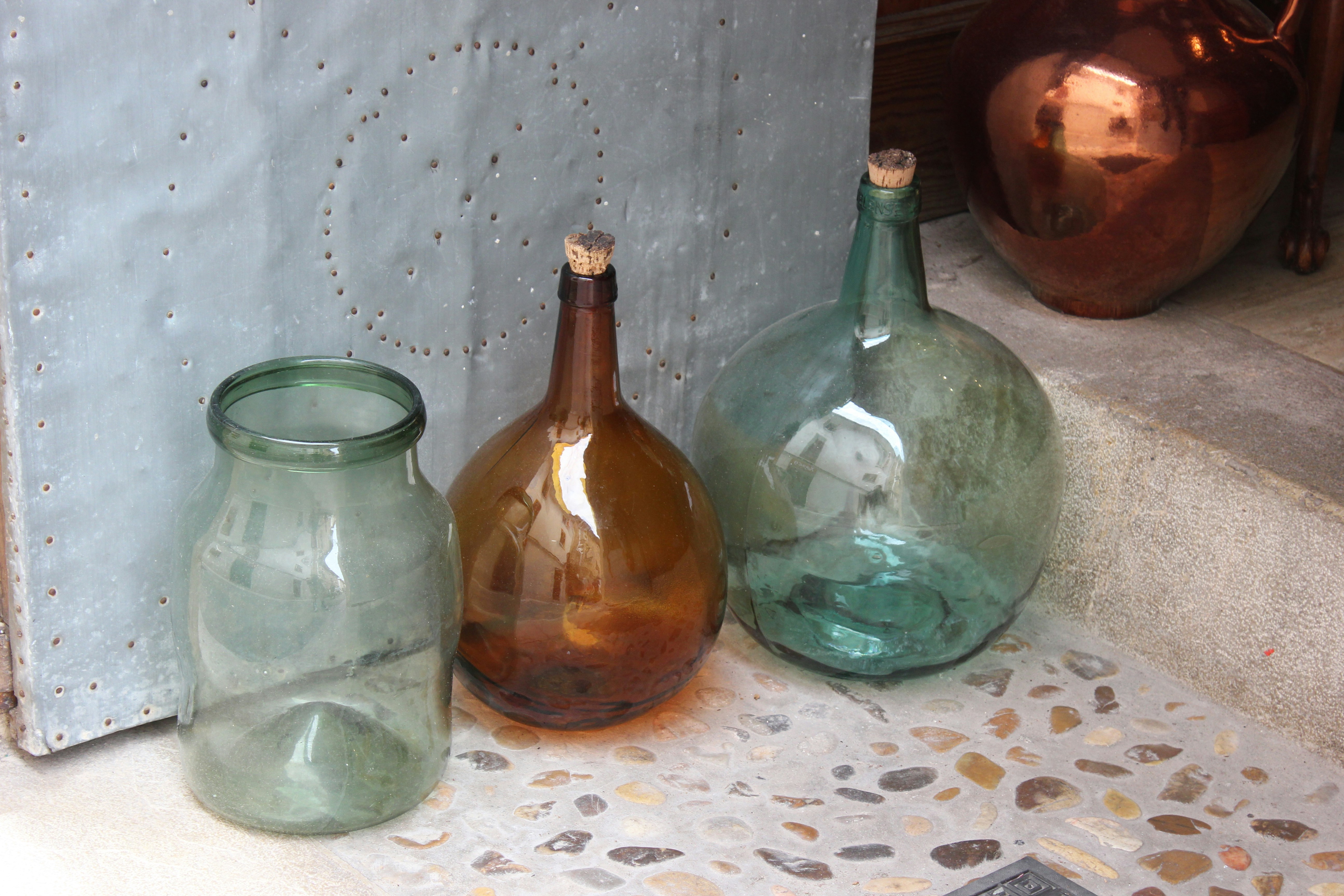 three different colored glass vases sitting on a counter