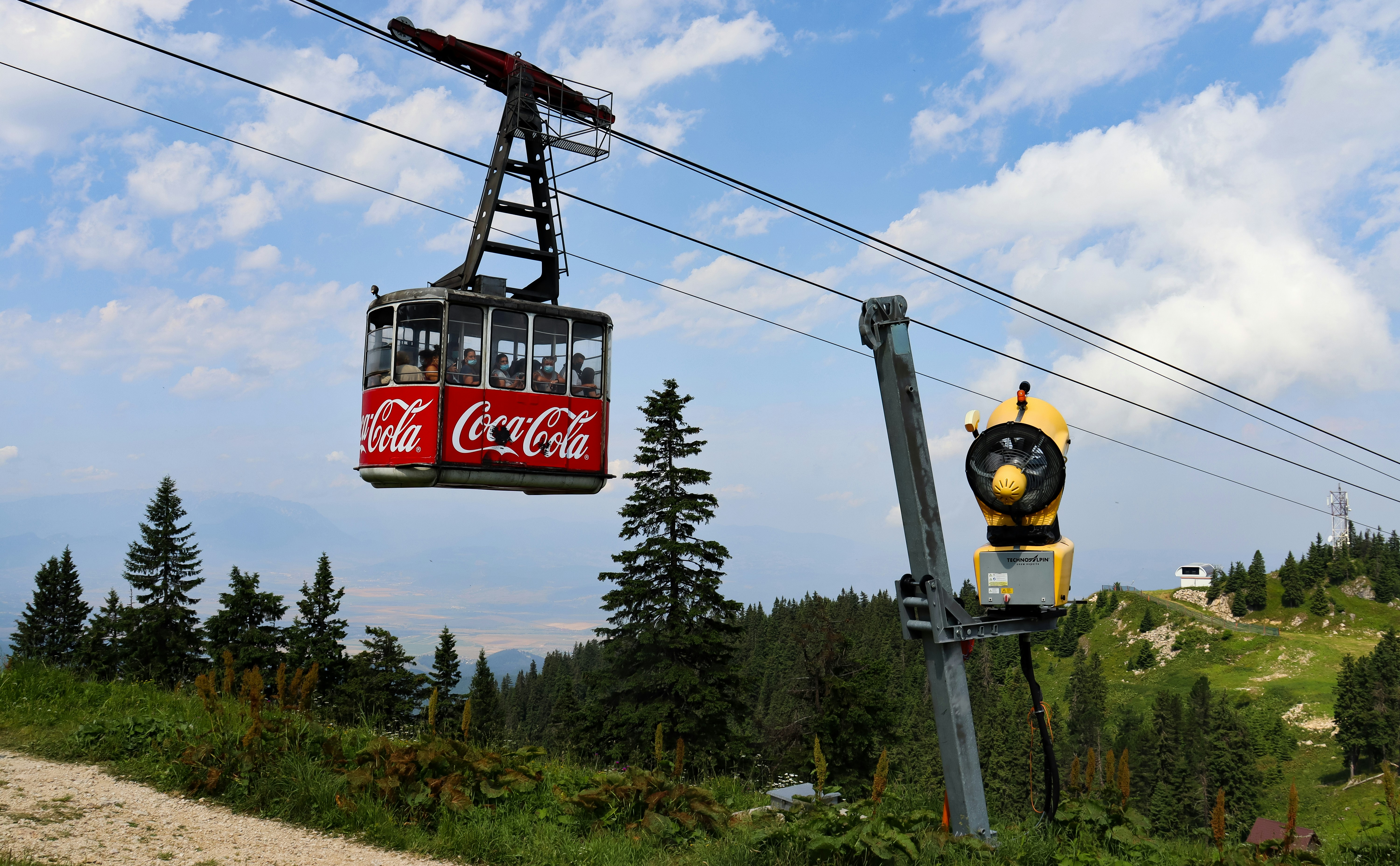 Crimson Gondola Car Crossing the Alpine Sky