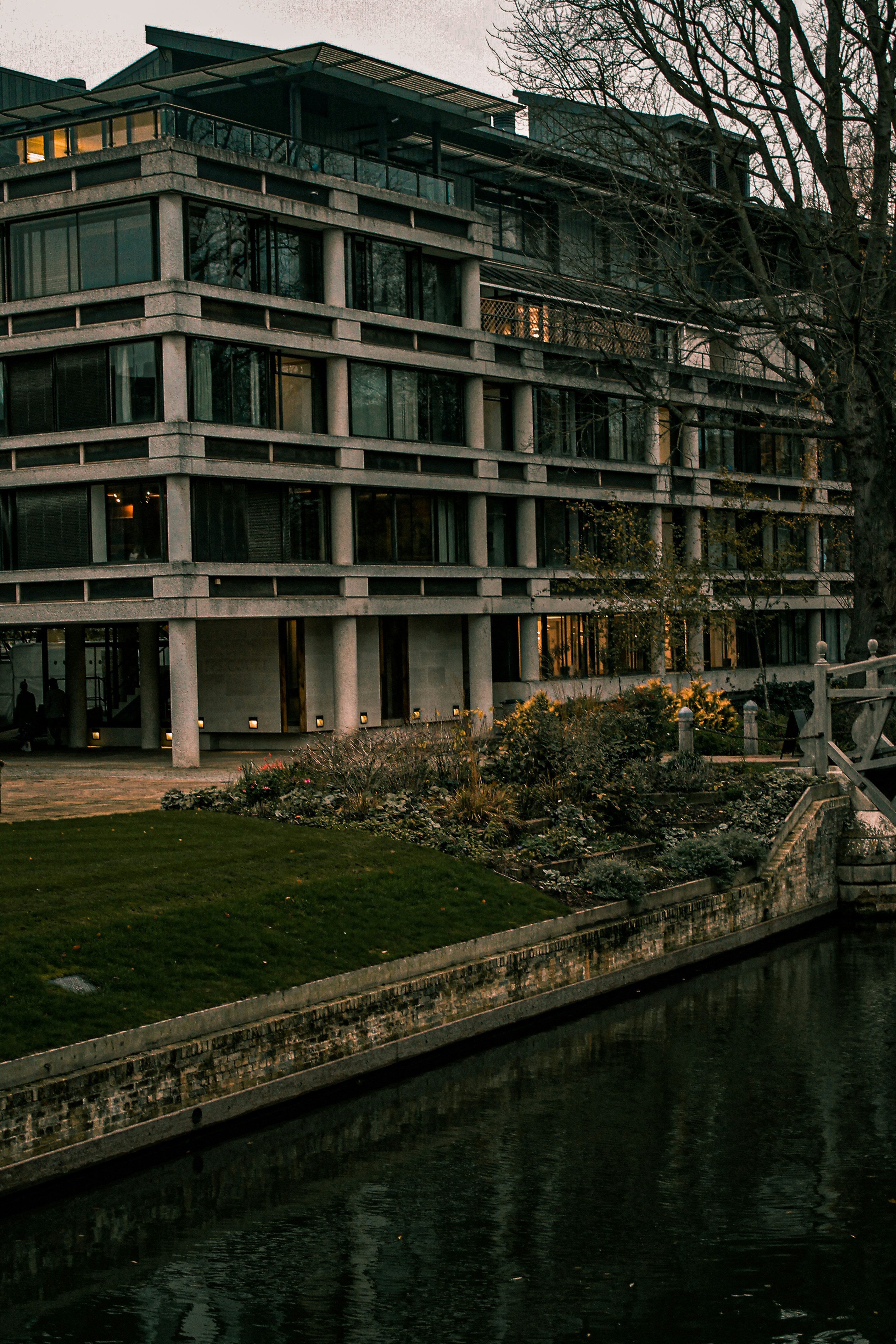 Canal Facades: Concrete Grids and Dusk-Warm Windows