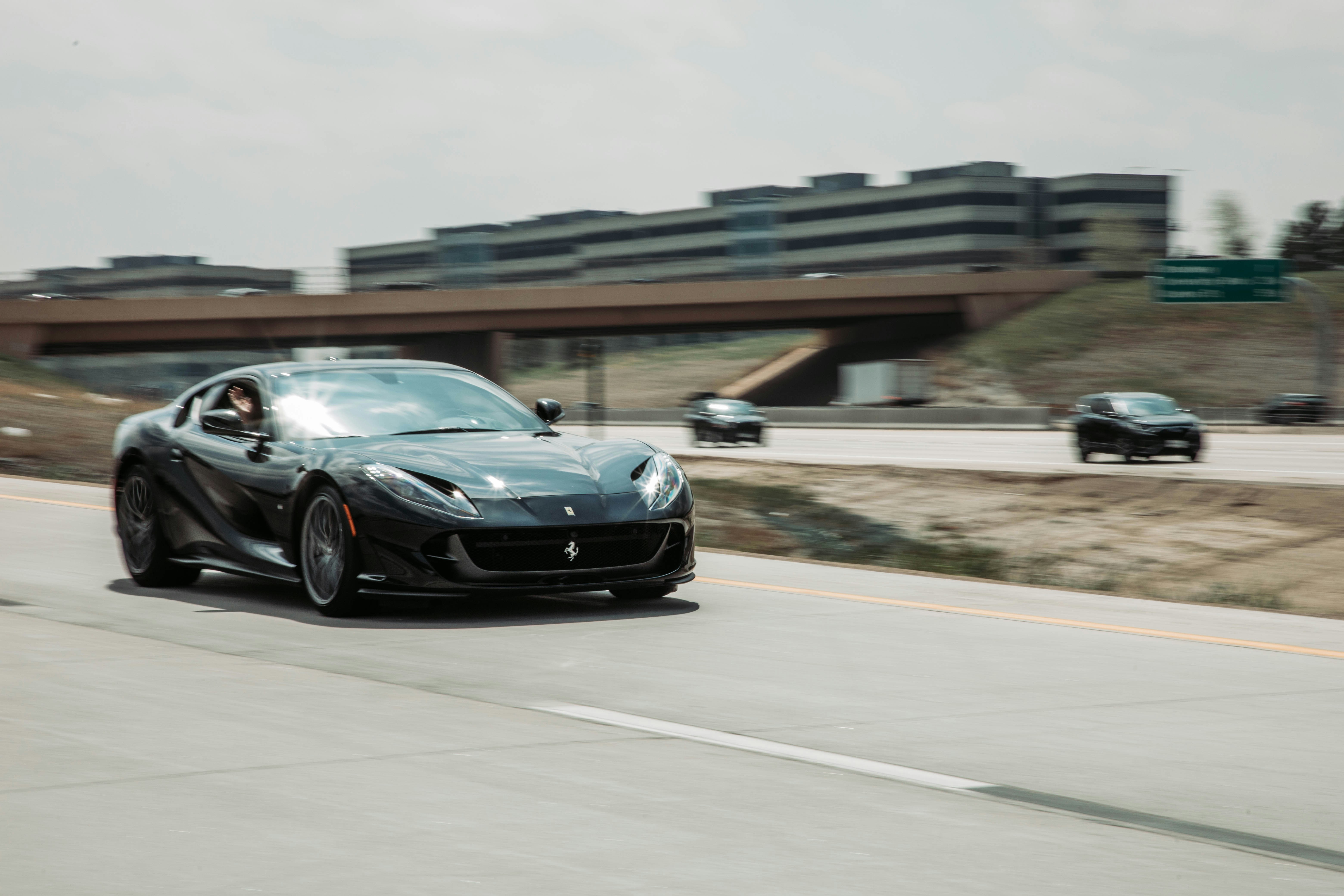 A black sports car driving down a highway photo – Free Denver Image on ...