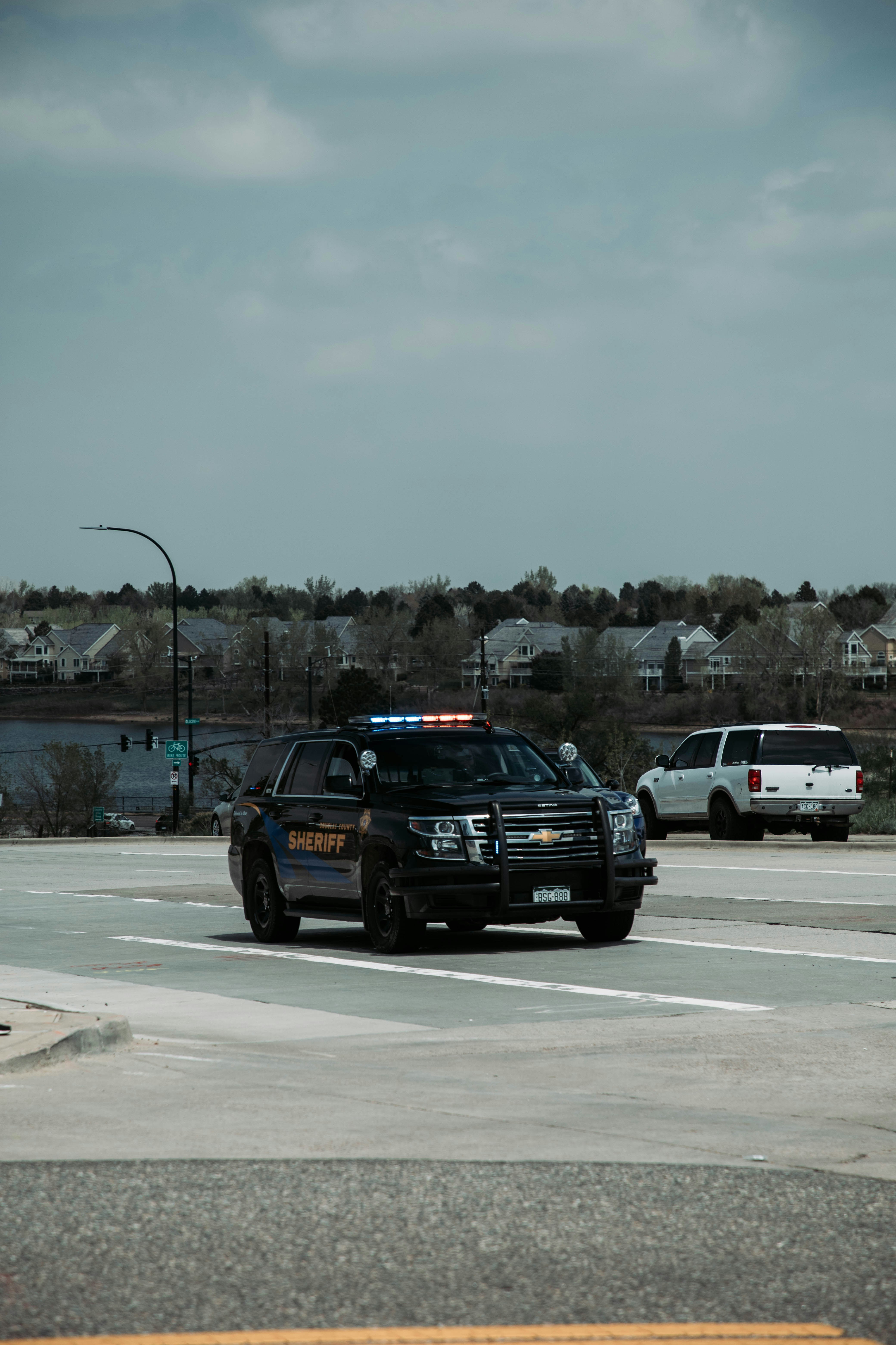A police car driving down a street next to a fire hydrant photo – Free ...