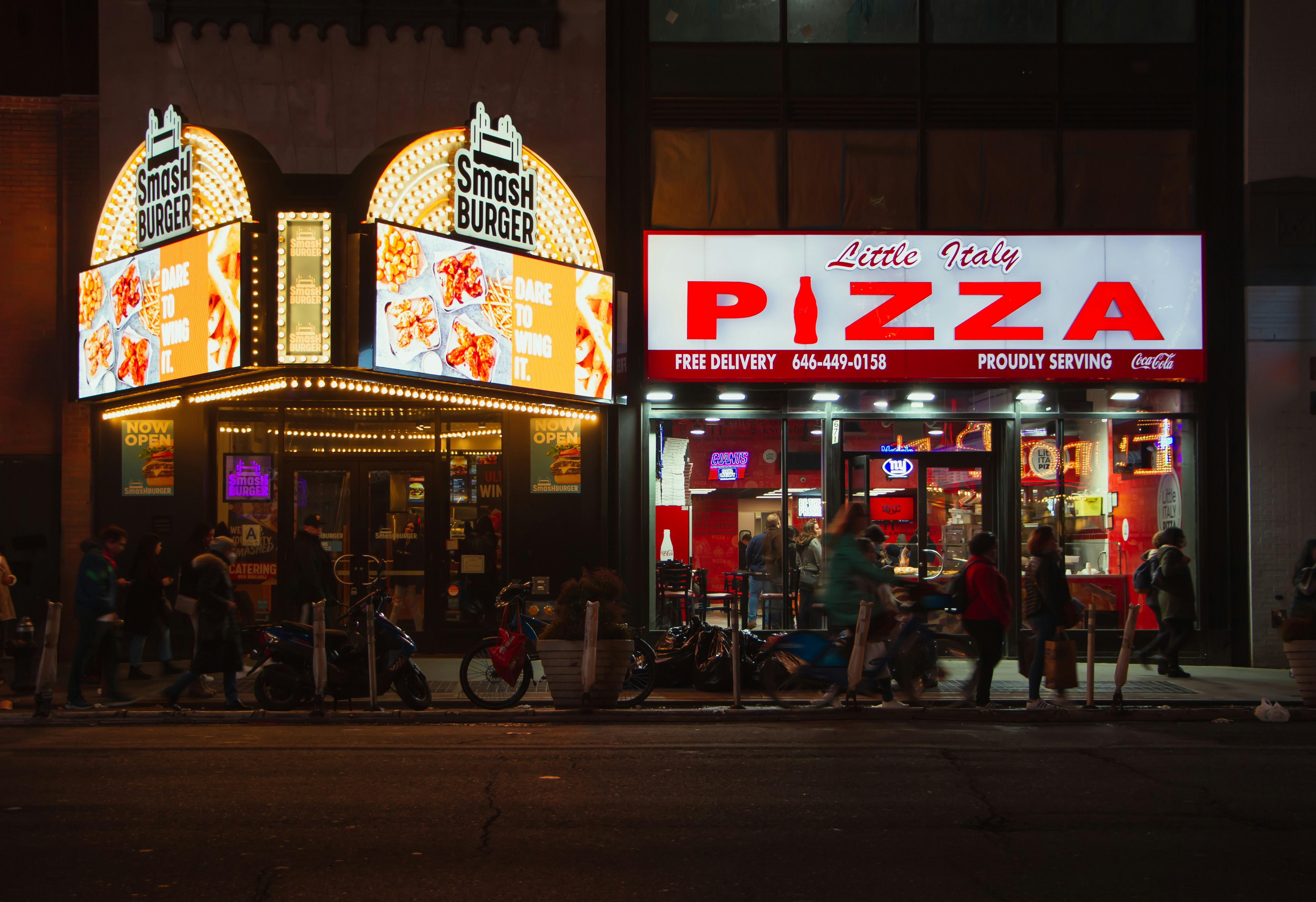 New York street, food, bicycles, and people at night.