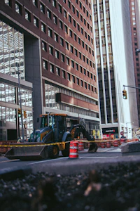 Backhoe at the Edge of Brick and Glass: A City Construction Scene