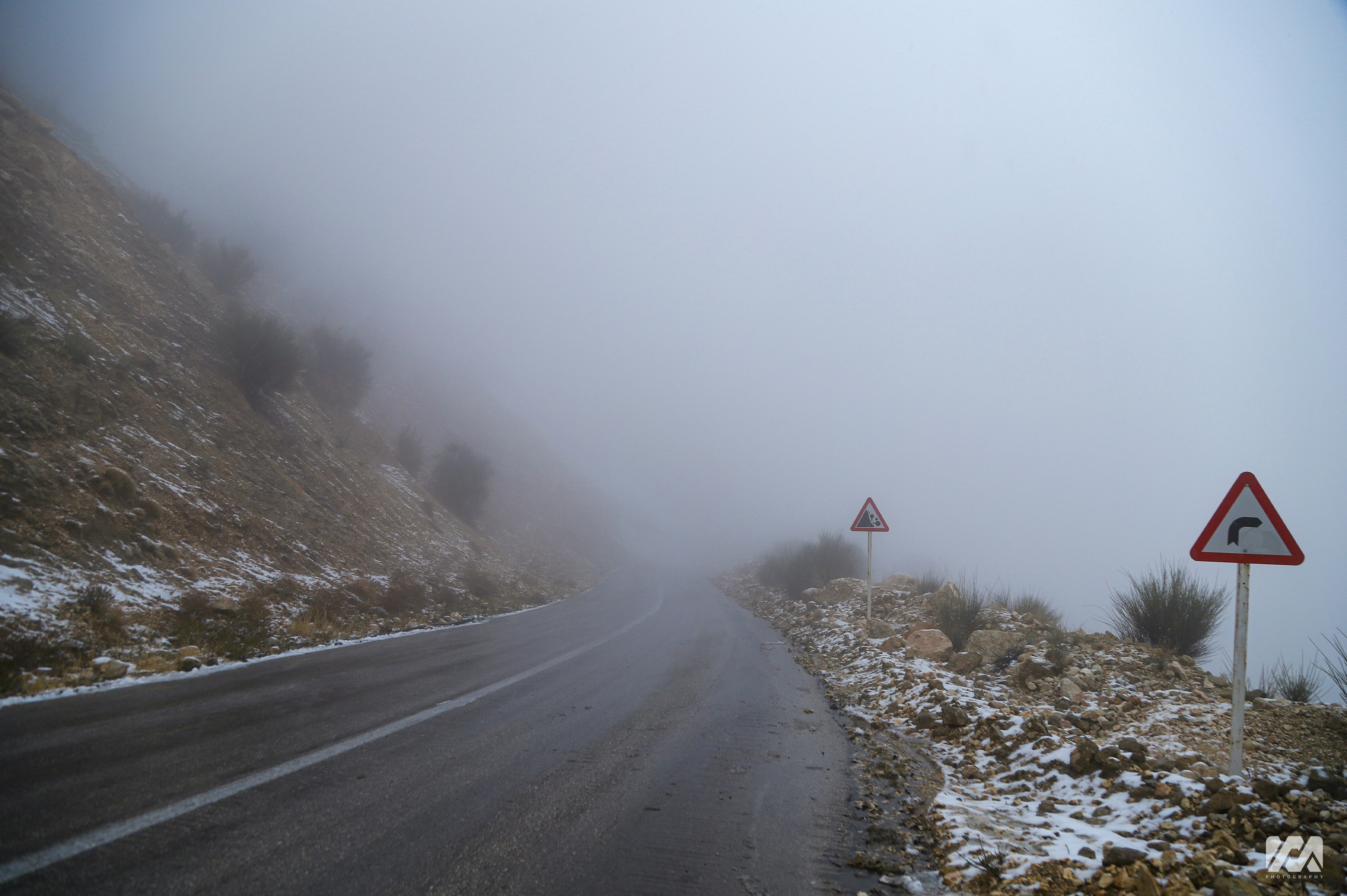 A foggy mountain road with a red and white sign photo – Free Darab ...