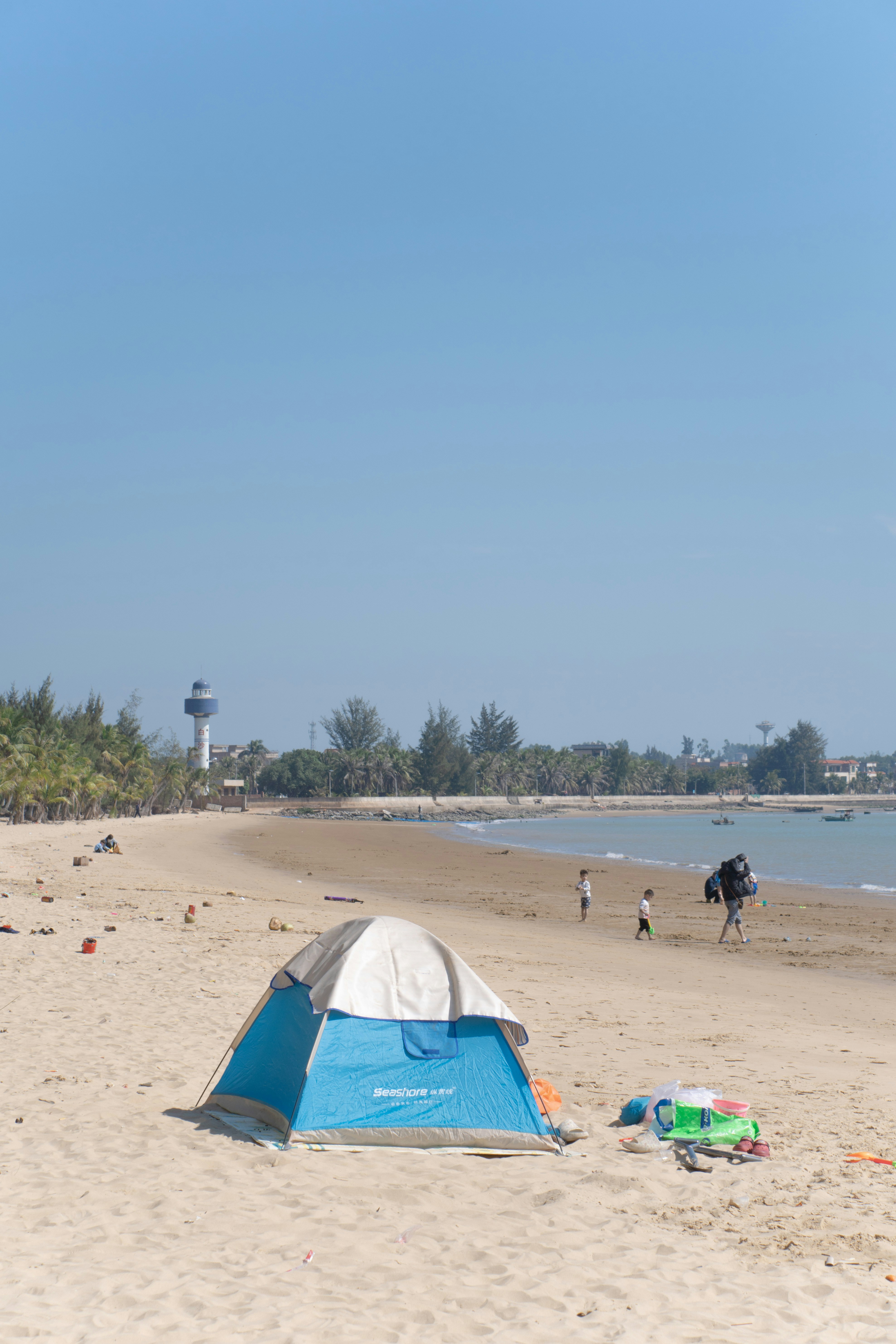 Blue Tent by the Quiet Shore: a Sunlit Beach Moment