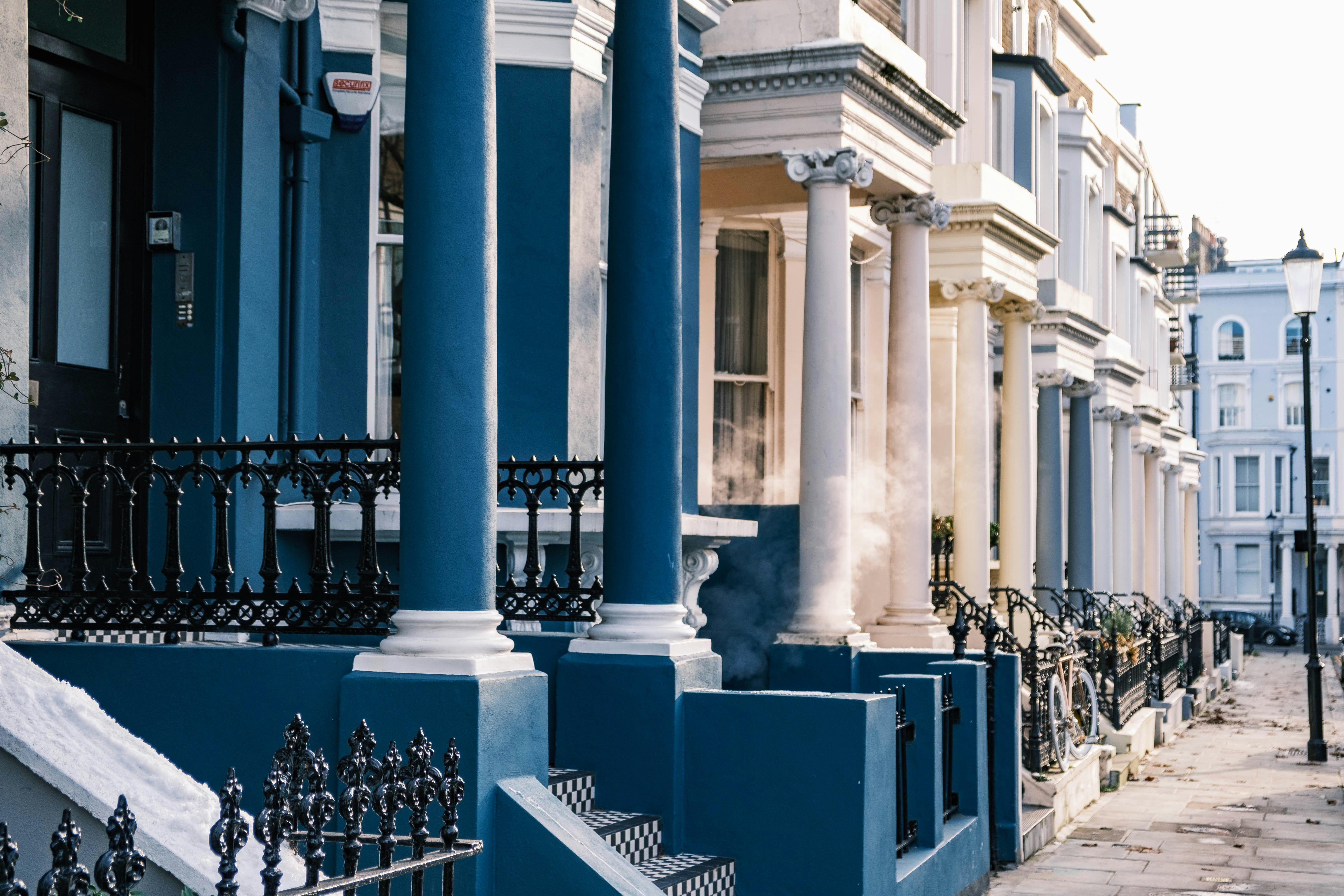 A row of blue and white buildings on a city street photo – Free Image ...