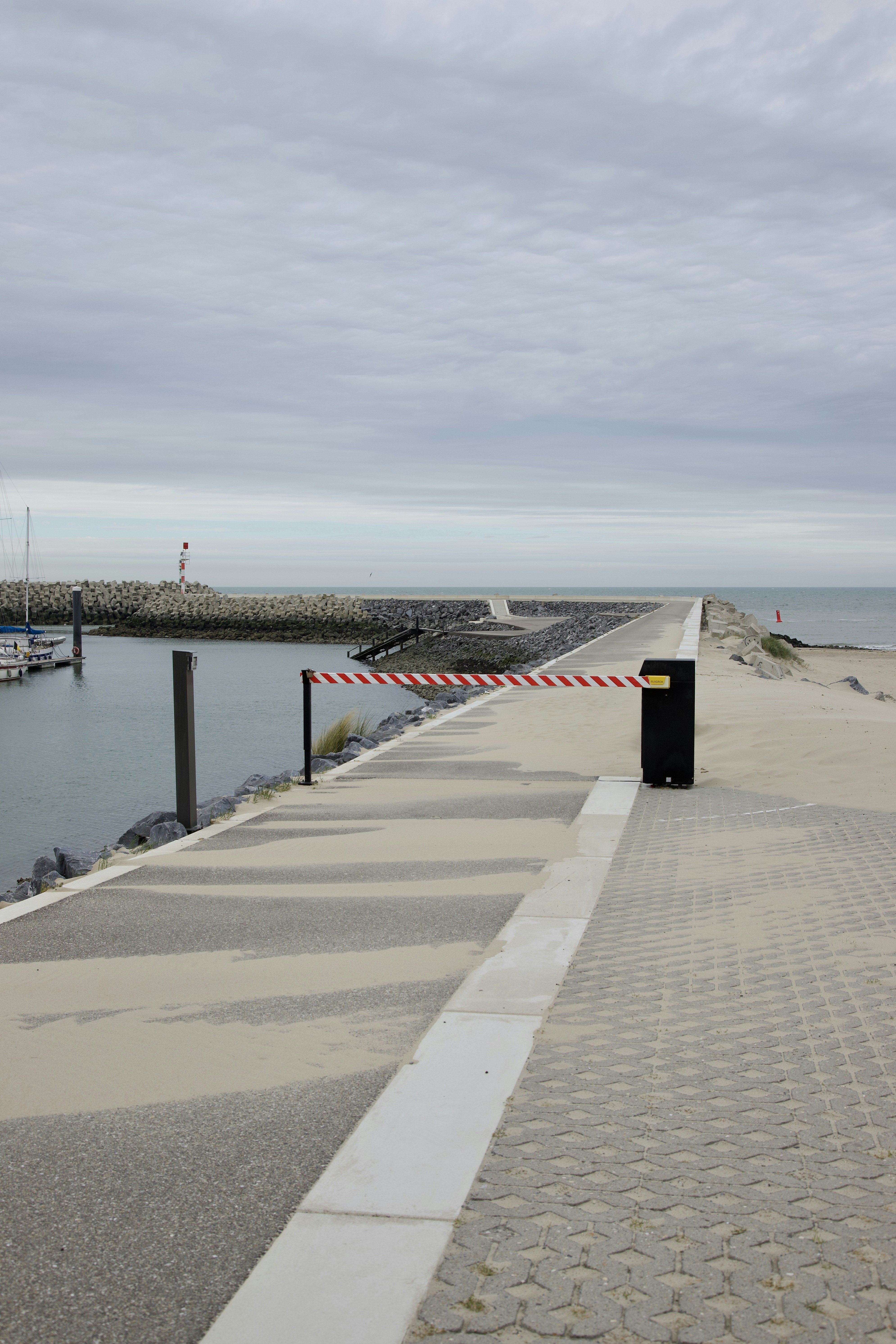 Red-Striped Barrier at the Quiet Seaside Jetty