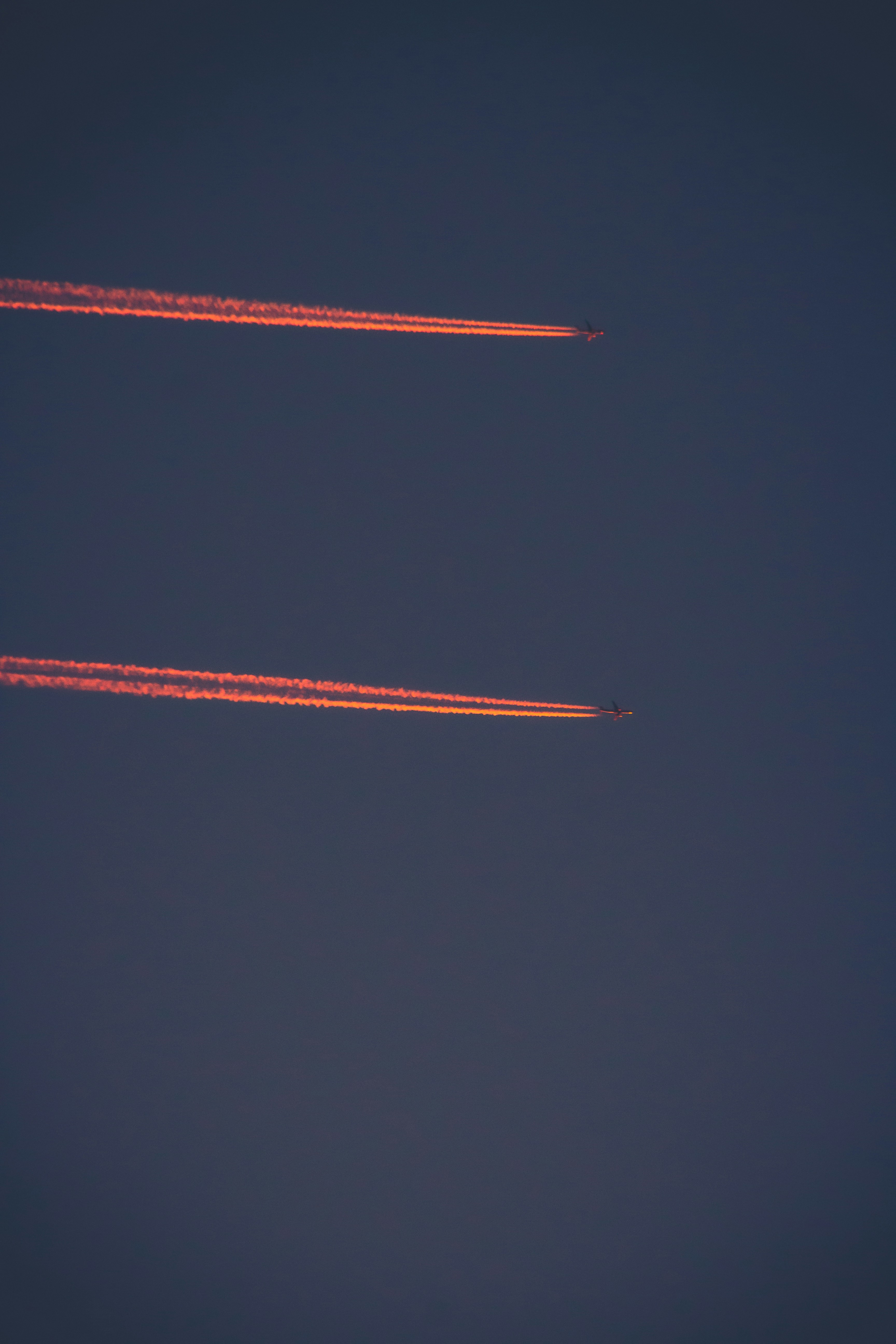 a couple of airplanes flying through a blue sky