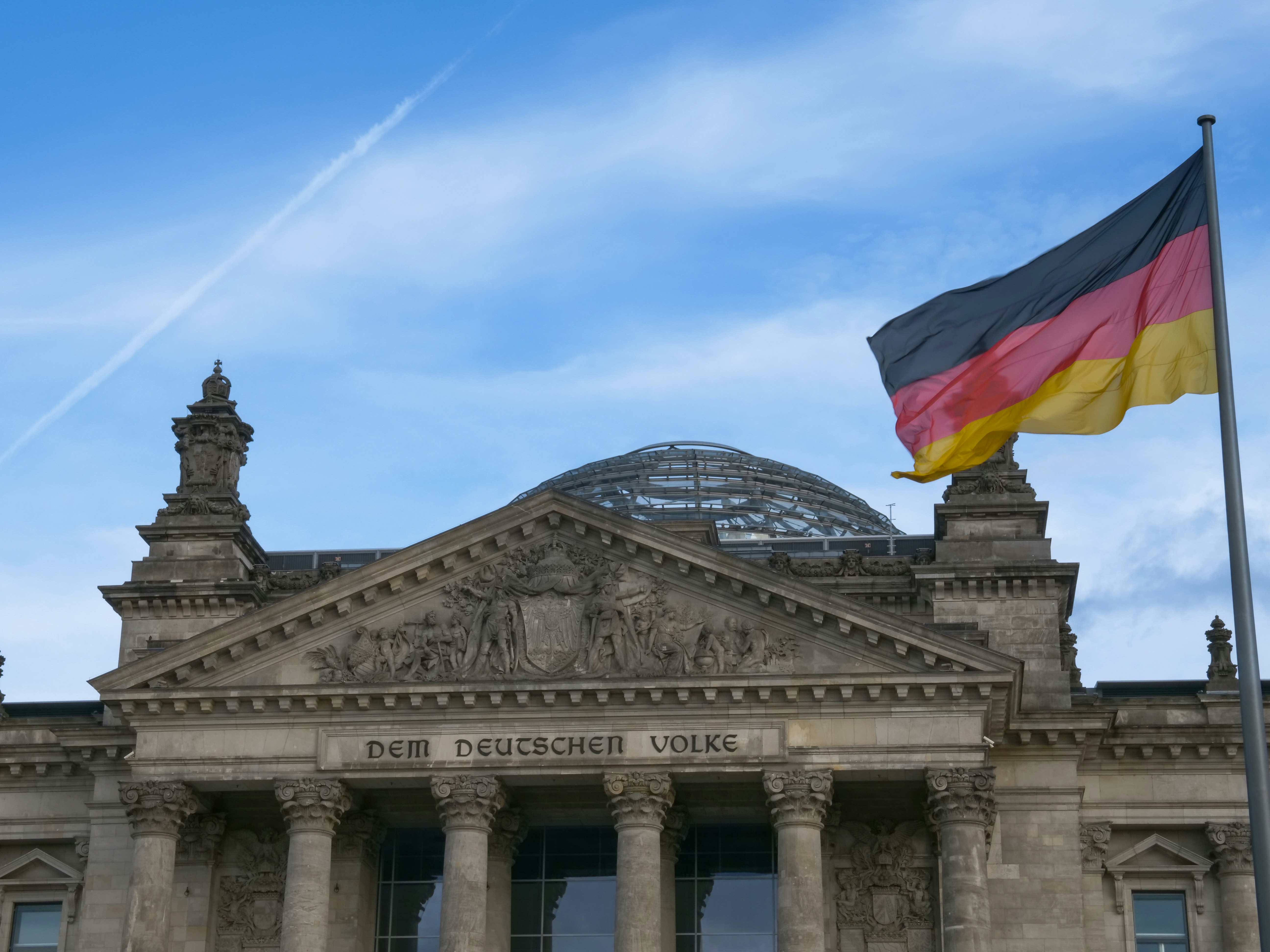 A german flag flying in front of a building photo – Free Berlin Image ...