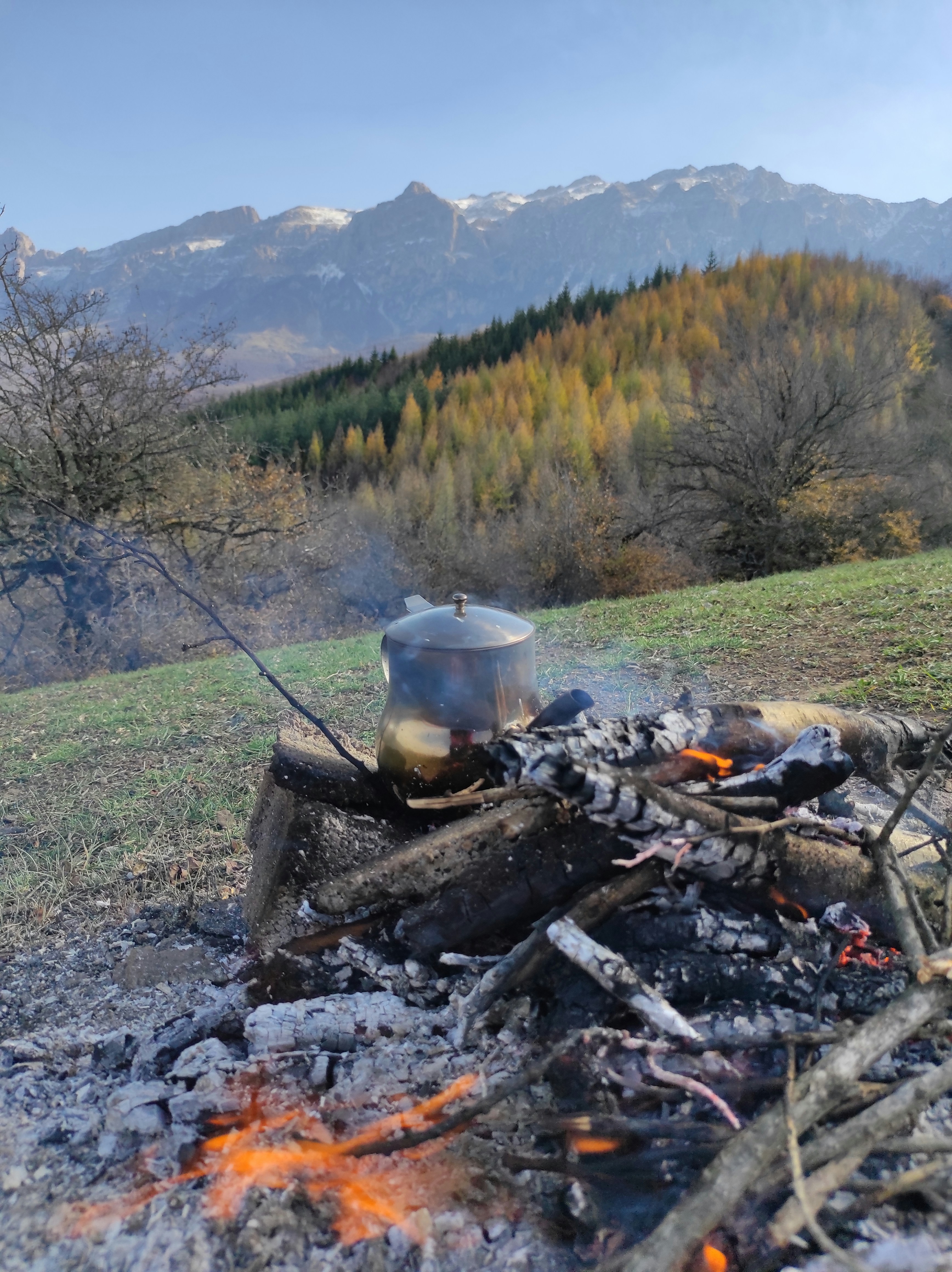 a pot sitting on top of a fire in the middle of a field
