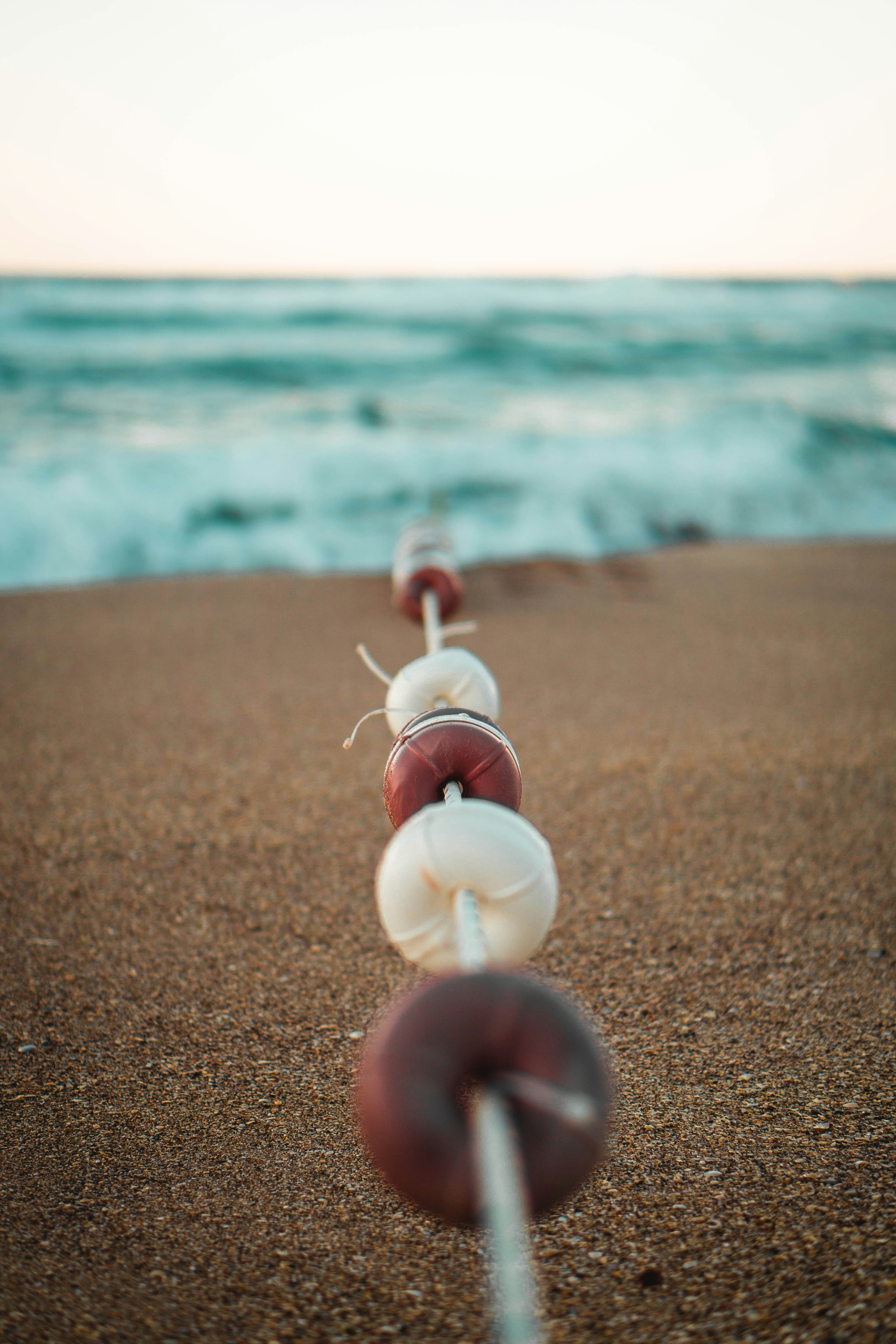 Bead-Line to the Horizon: A Beach Buoy Column Quietly Reaching the Sea