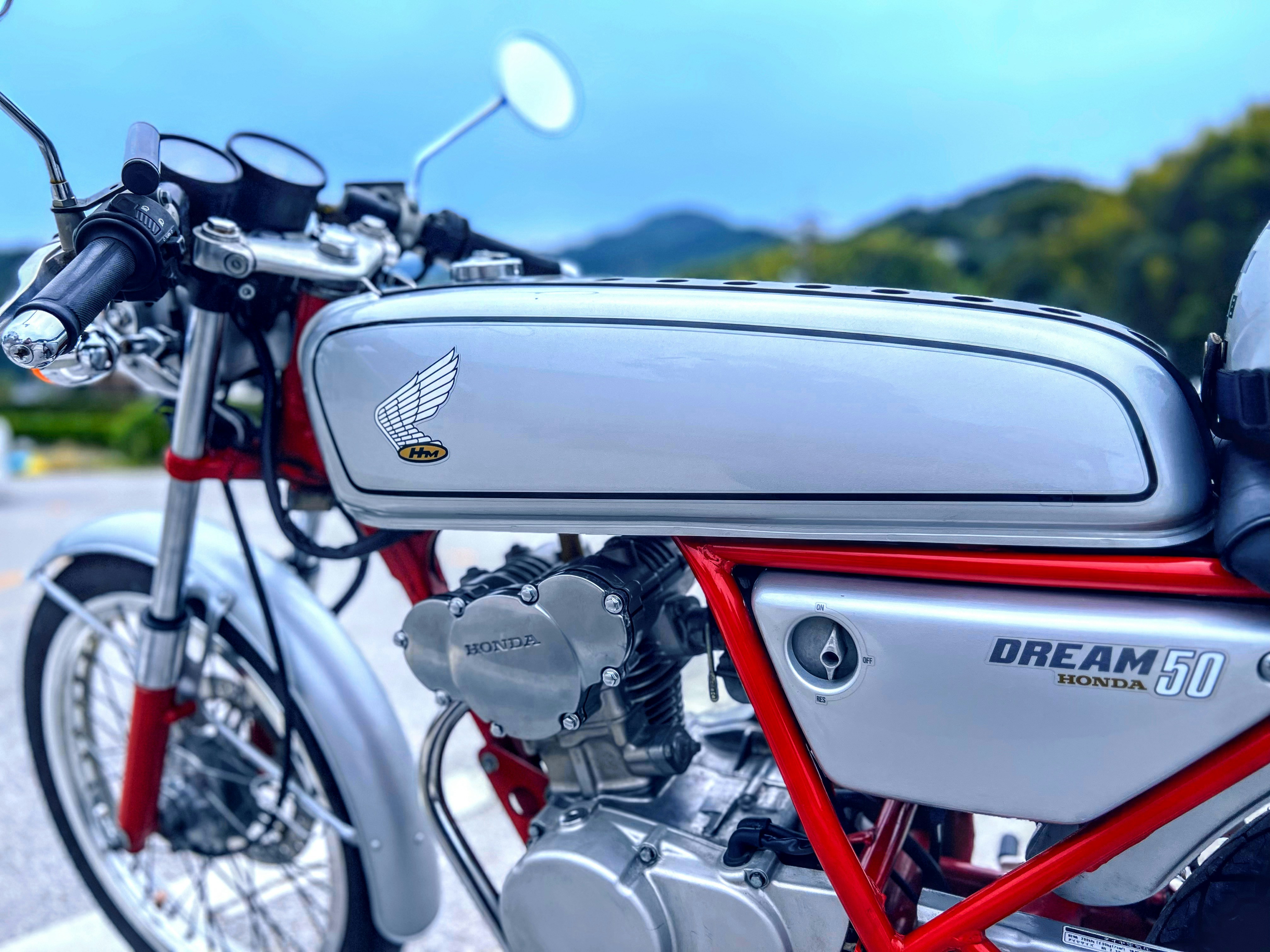 A red and silver motorcycle parked on the side of a road photo – Free ...