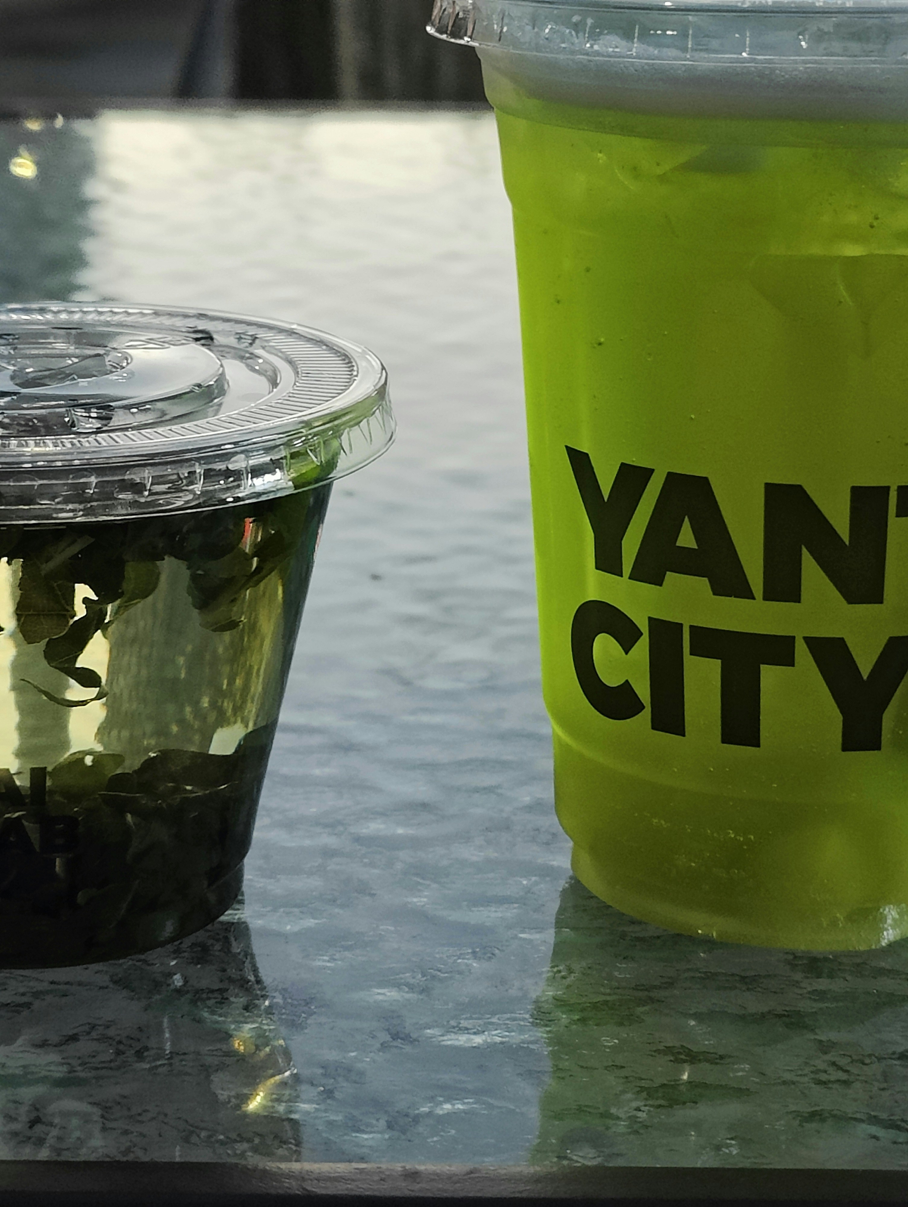 A plastic cup and a plastic container sitting on a table photo – Free ...