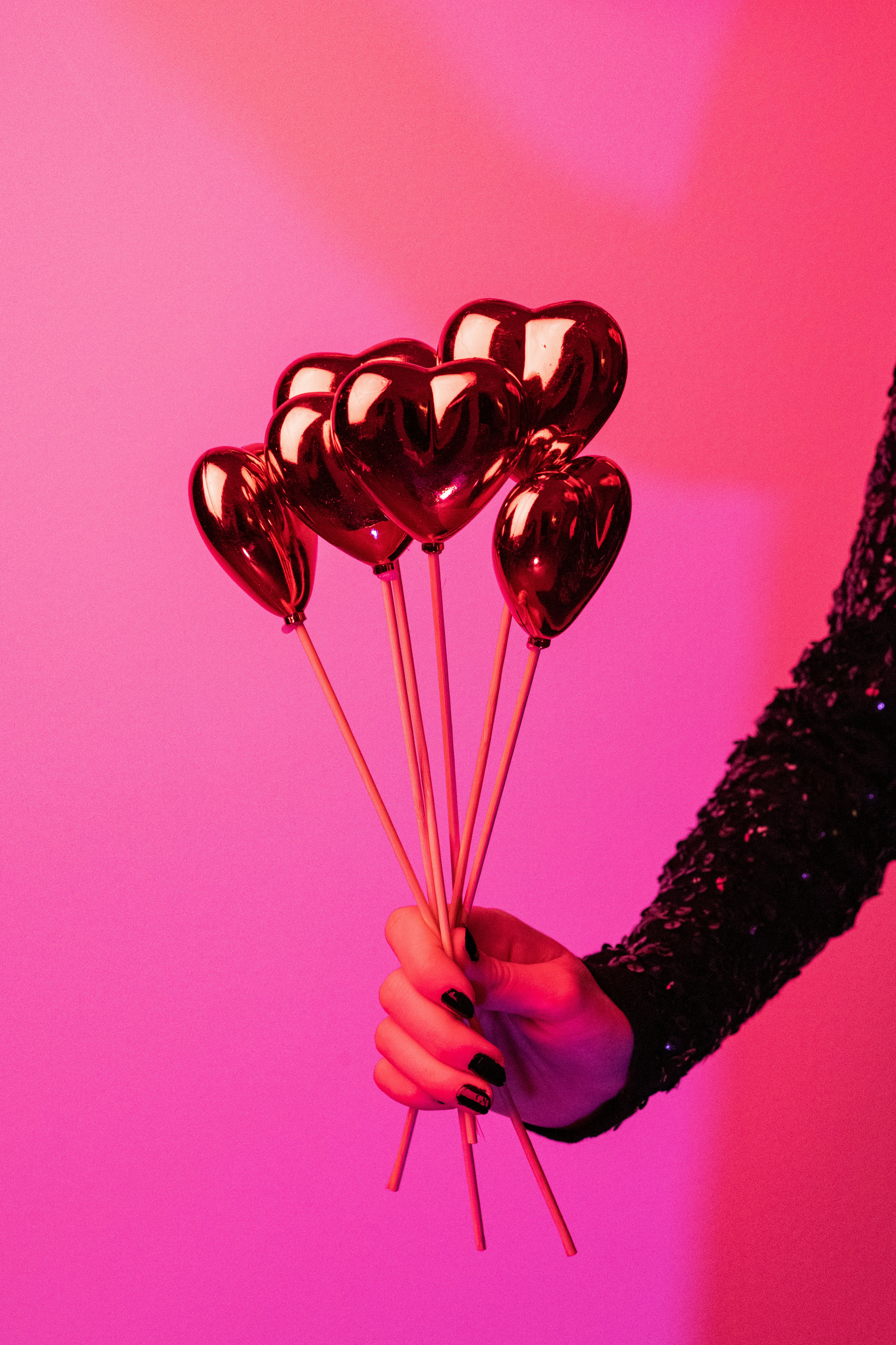 a person holding a bunch of heart shaped balloons