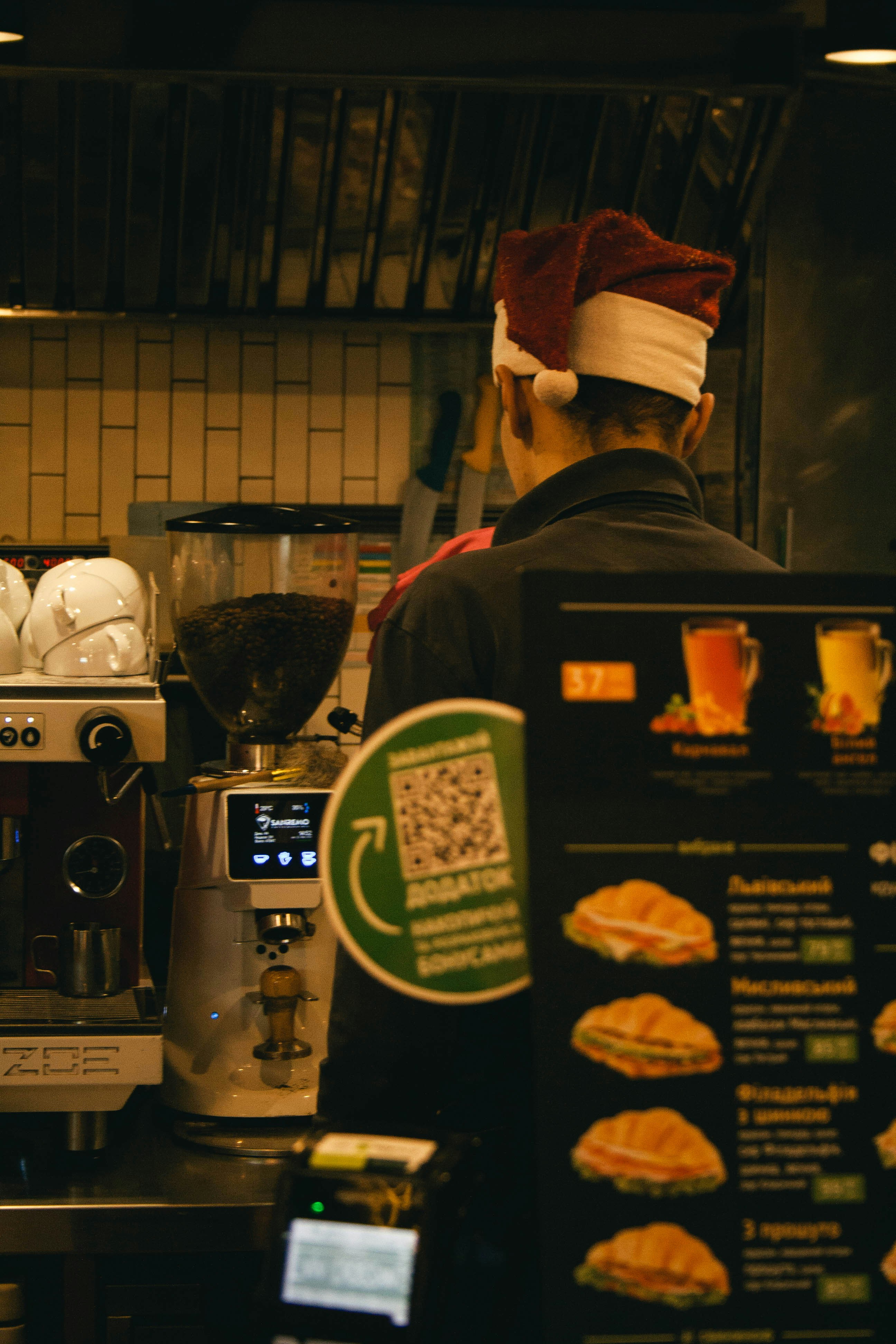 Santa-Hatted Barista Behind the Espresso Counter