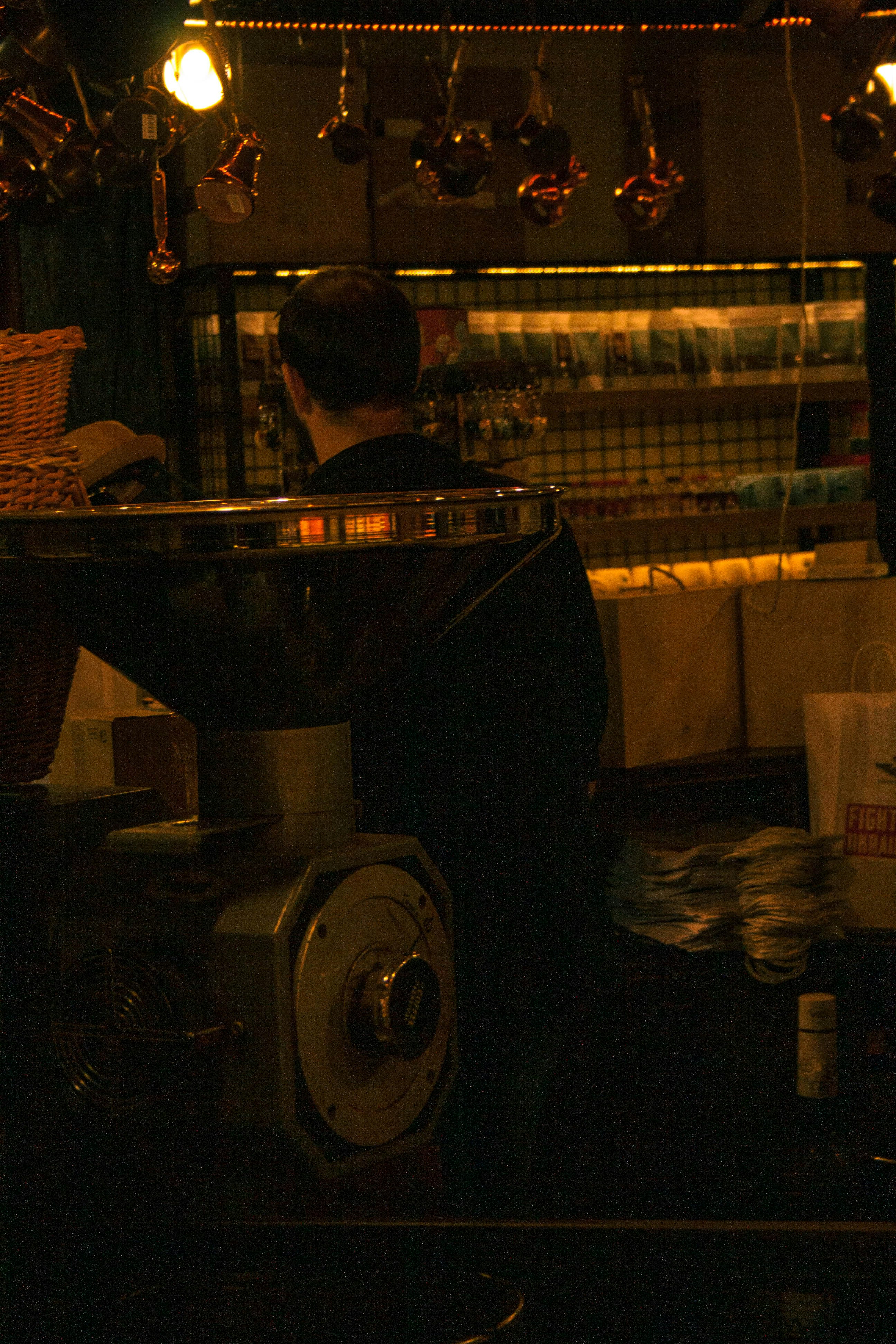 Counterlight Moment: A Back-Facing Figure at a Warmly Lit Café Counter