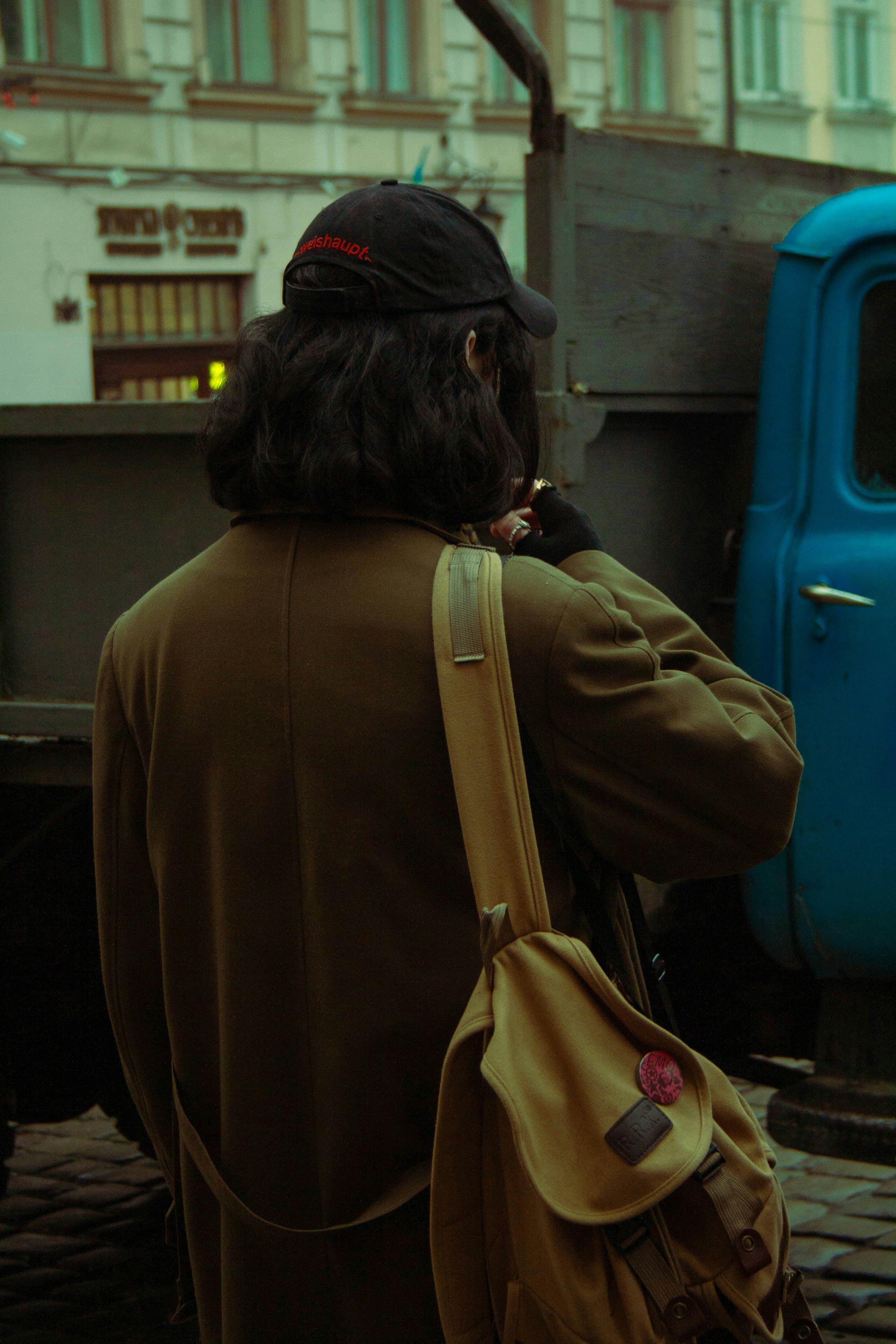 Urban Back View: Olive Coat, Tan Backpack, and a Quiet Street