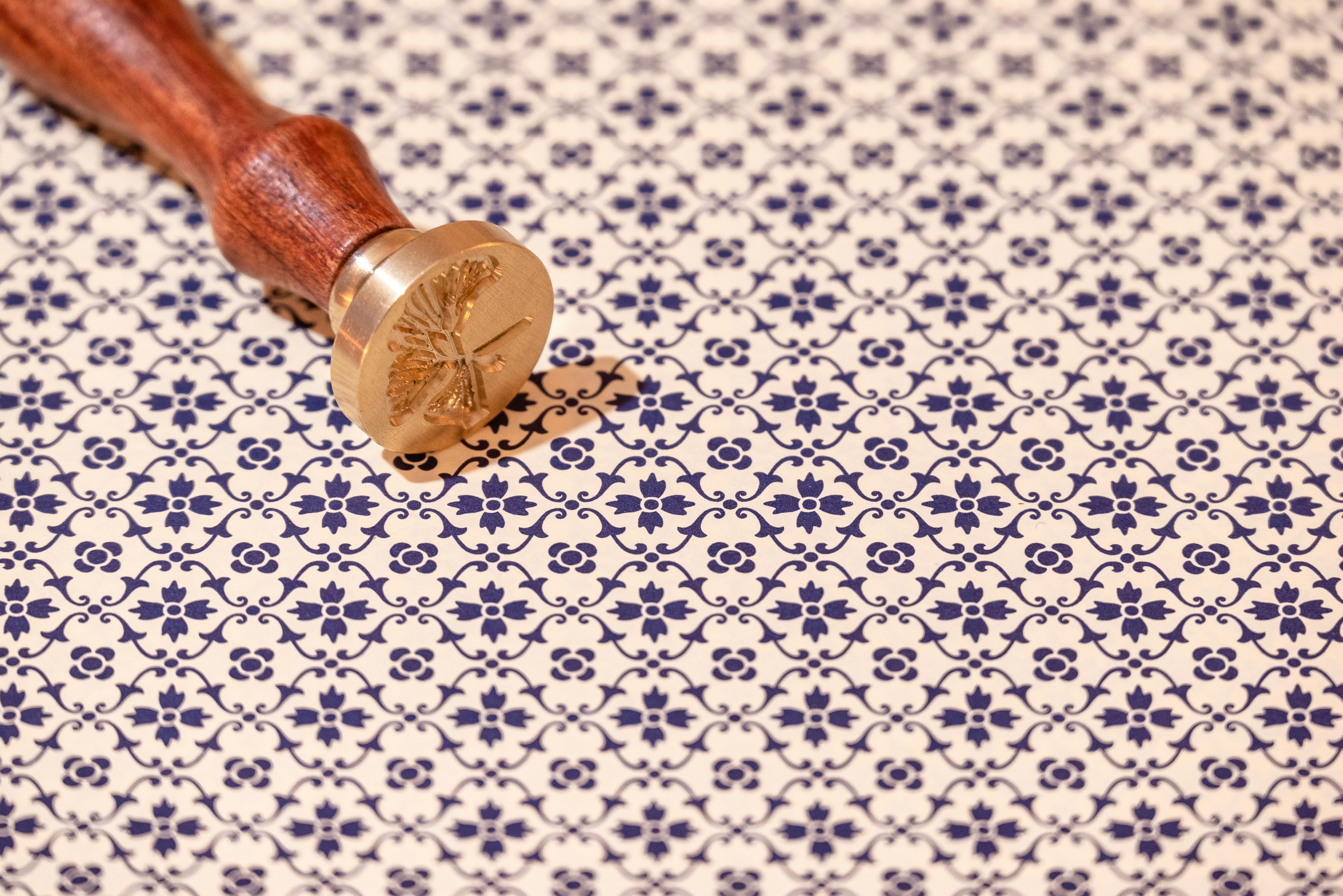 A wooden stamper sitting on top of a blue and white table cloth photo ...