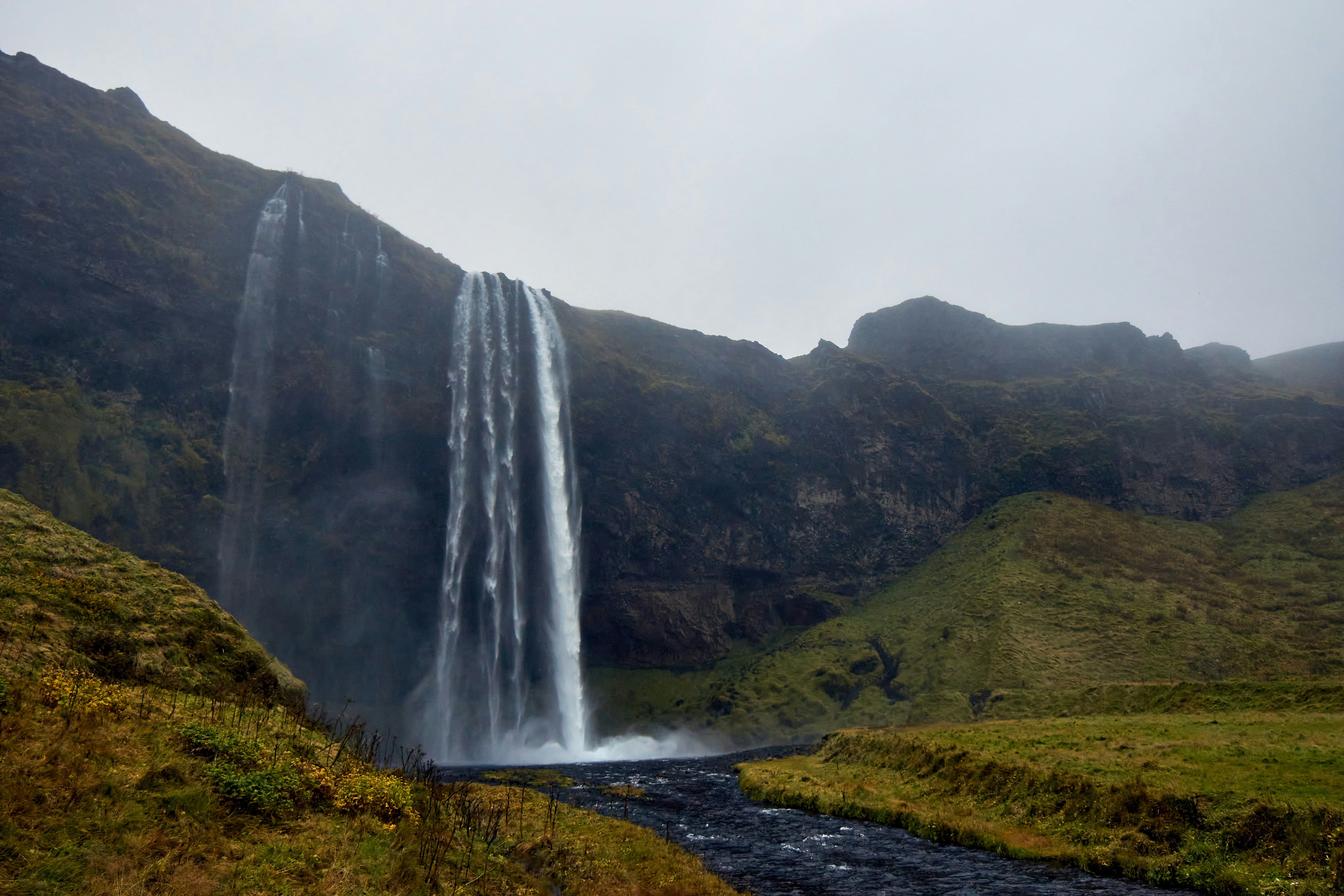 A very tall waterfall in the middle of a mountain photo – Free Nature ...