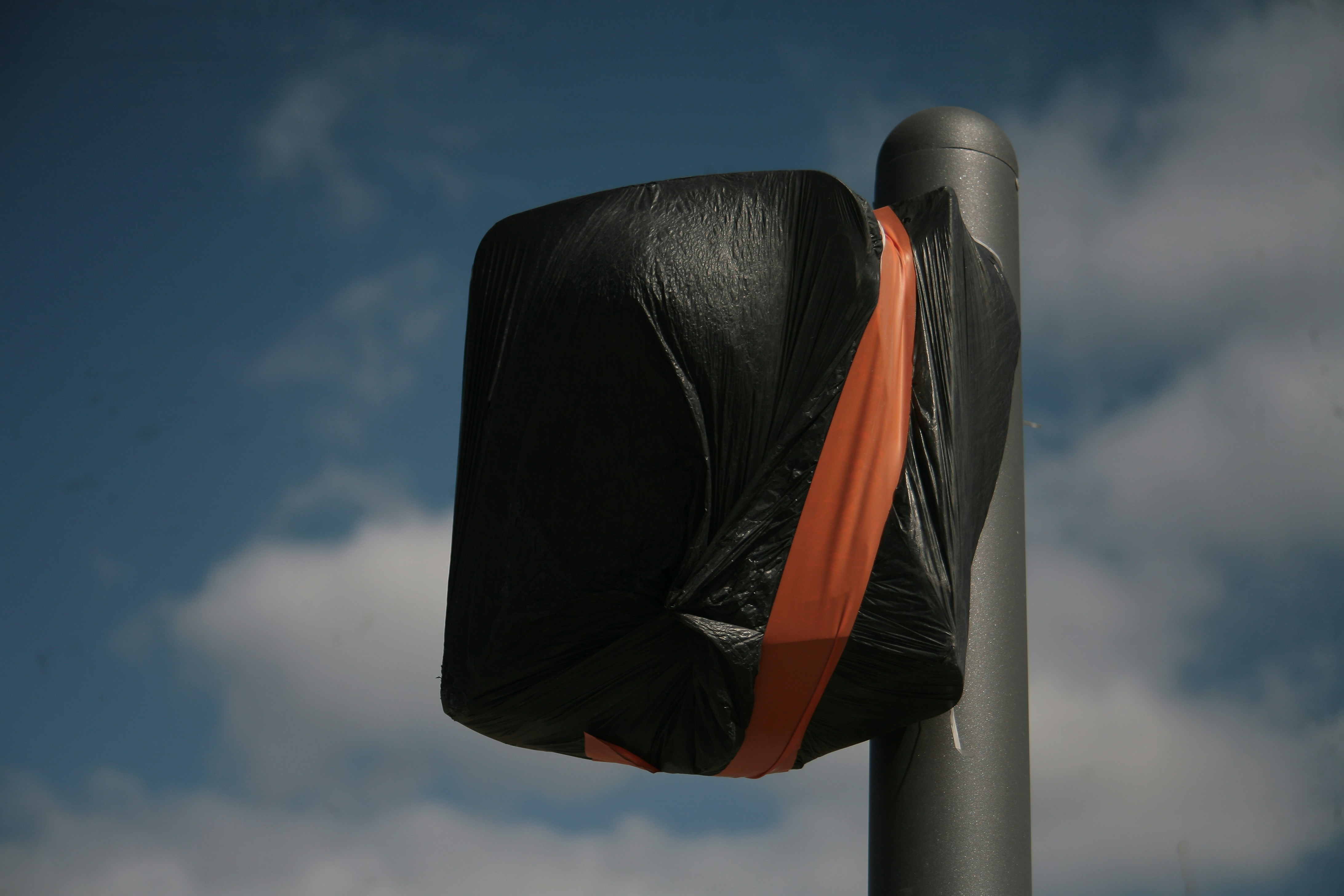 Wrapped Signal on a Steel Post Under a Cerulean Sky