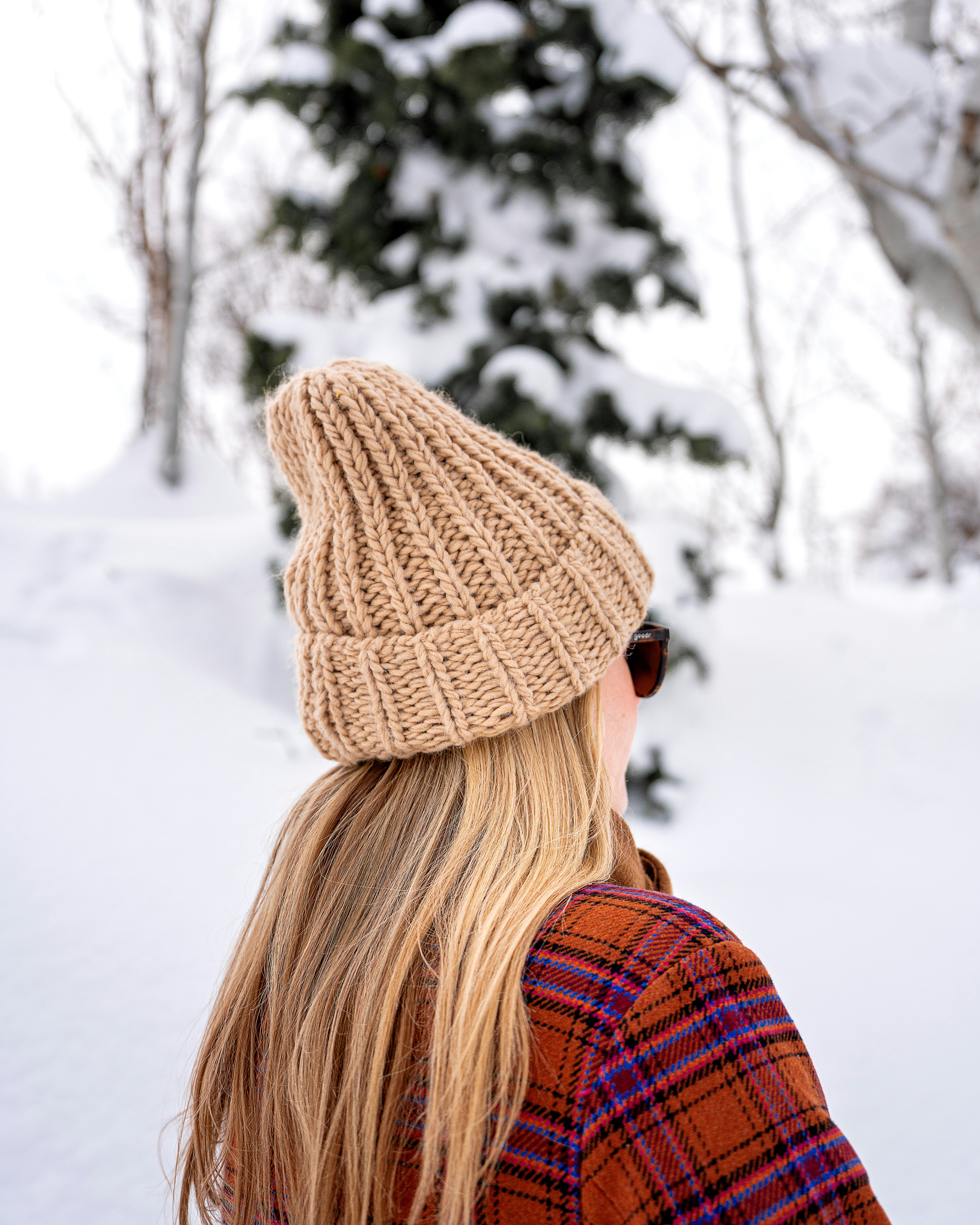A woman wearing a knitted hat in the snow photo – Free Woman Image on ...