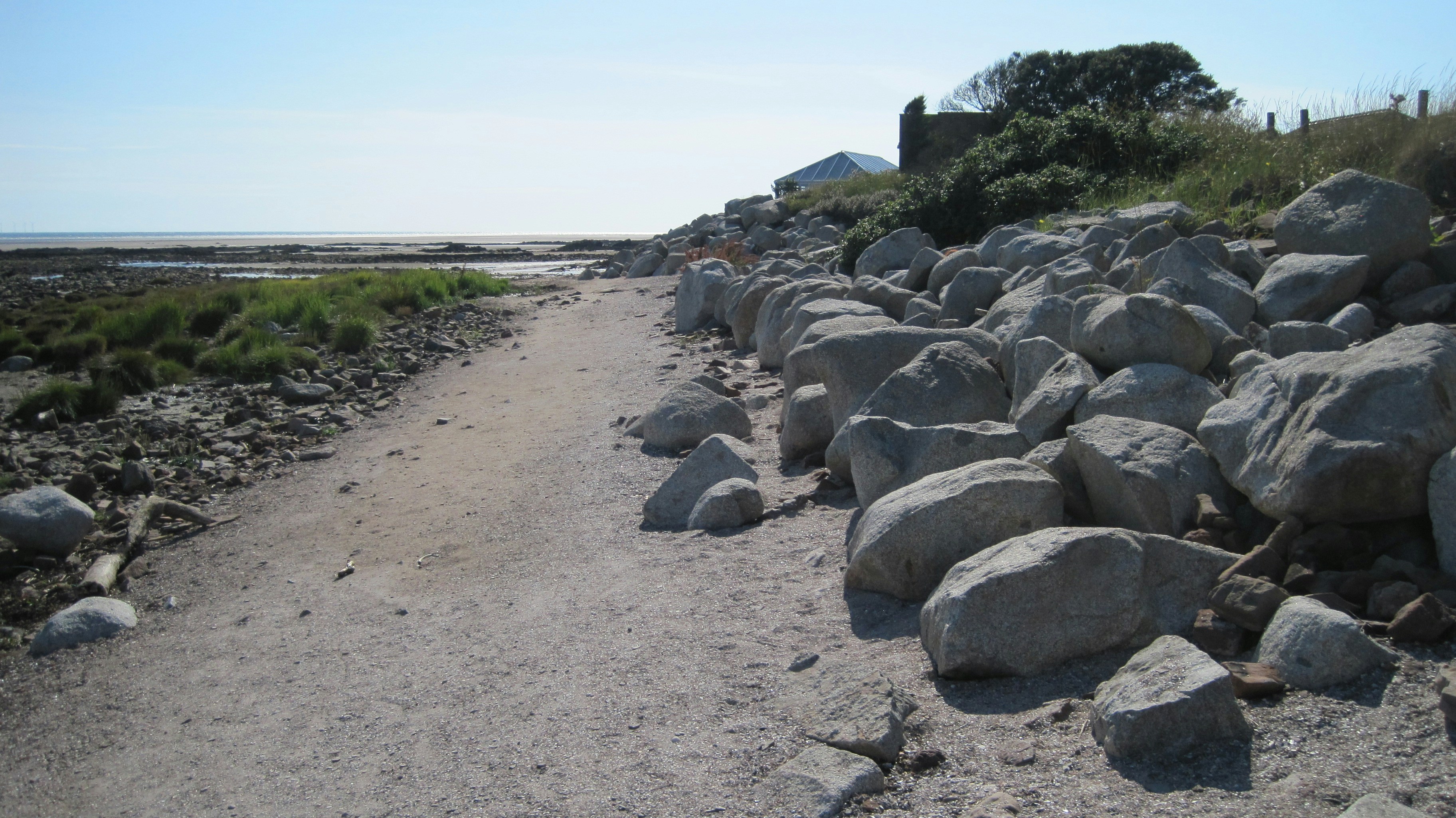 A gravel road with large rocks on the side of it photo – Free ...