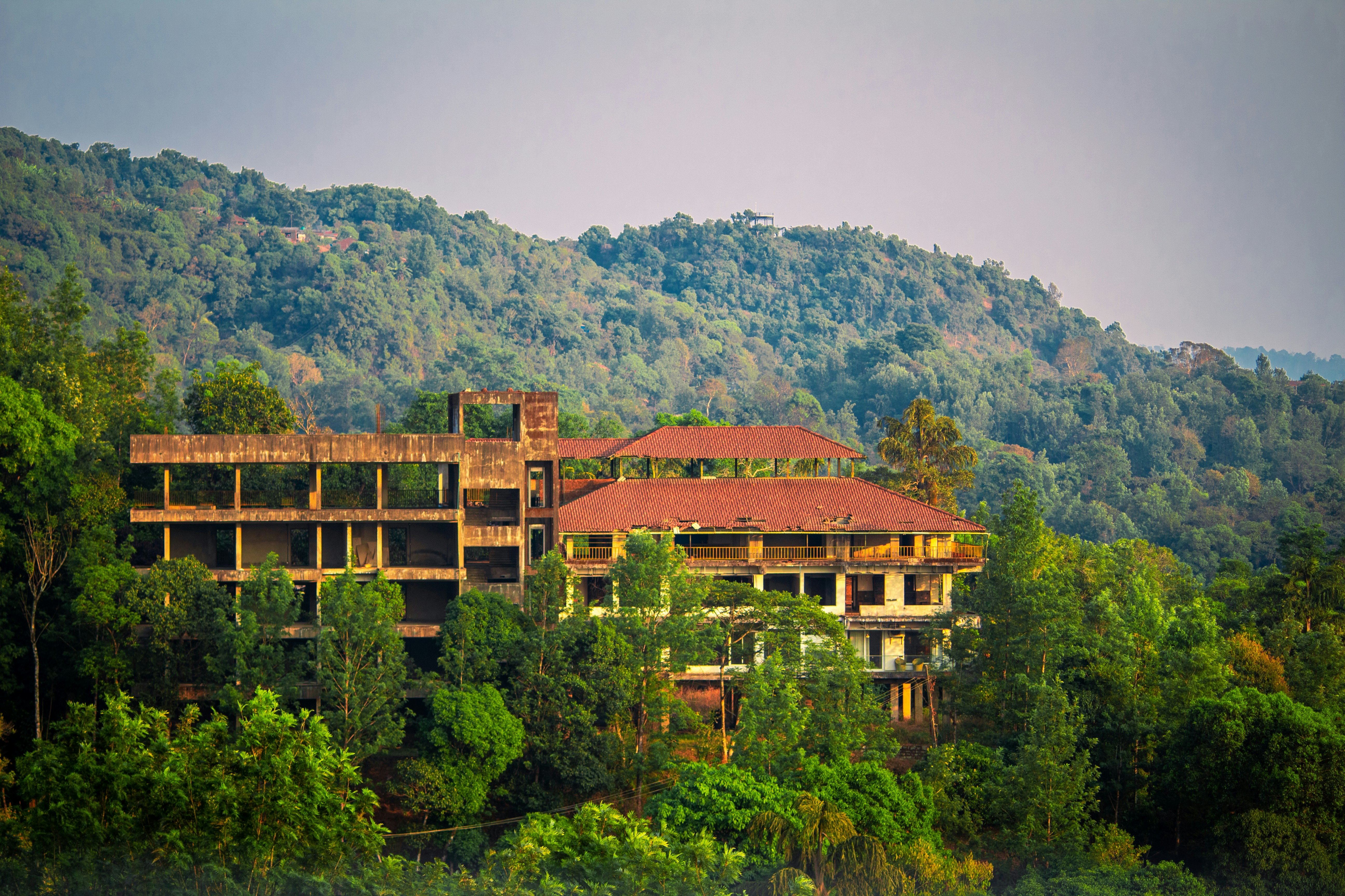 A large building sitting on top of a lush green hillside photo – Free ...