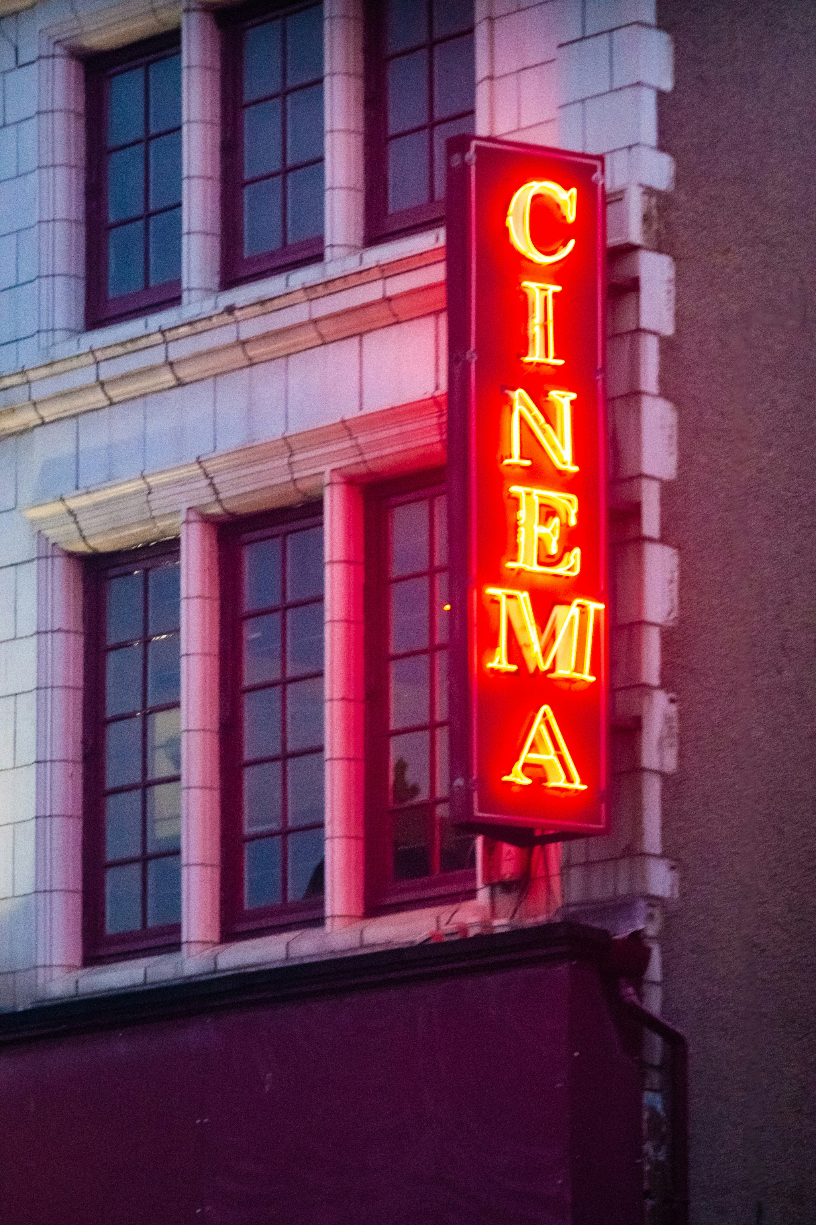 A neon sign that reads cinema on the side of a building photo – Free ...