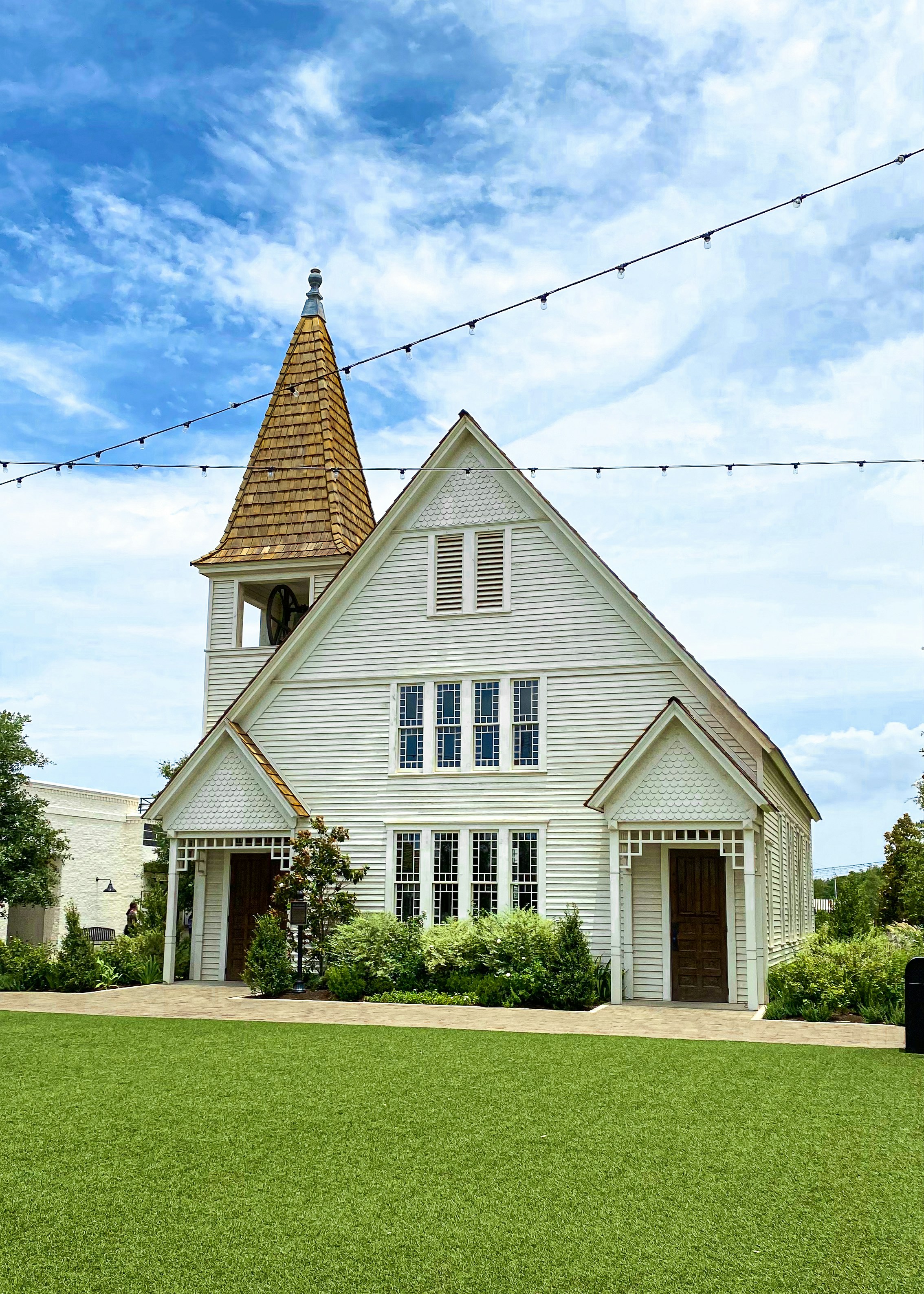 White-Gabled Chapel with Bell Tower Under a String-Lit Sky