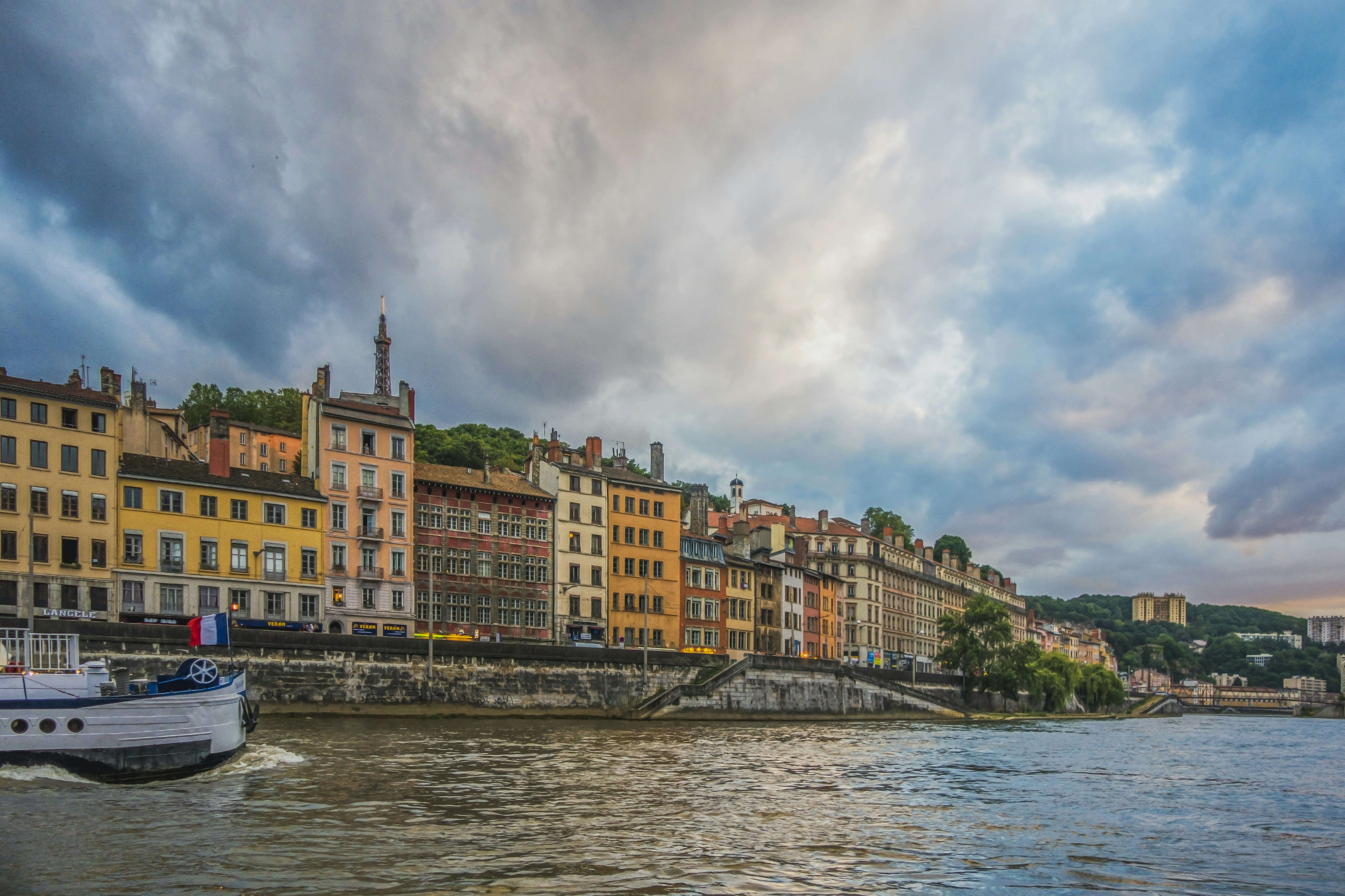 A boat traveling down a river next to tall buildings photo – Free City ...