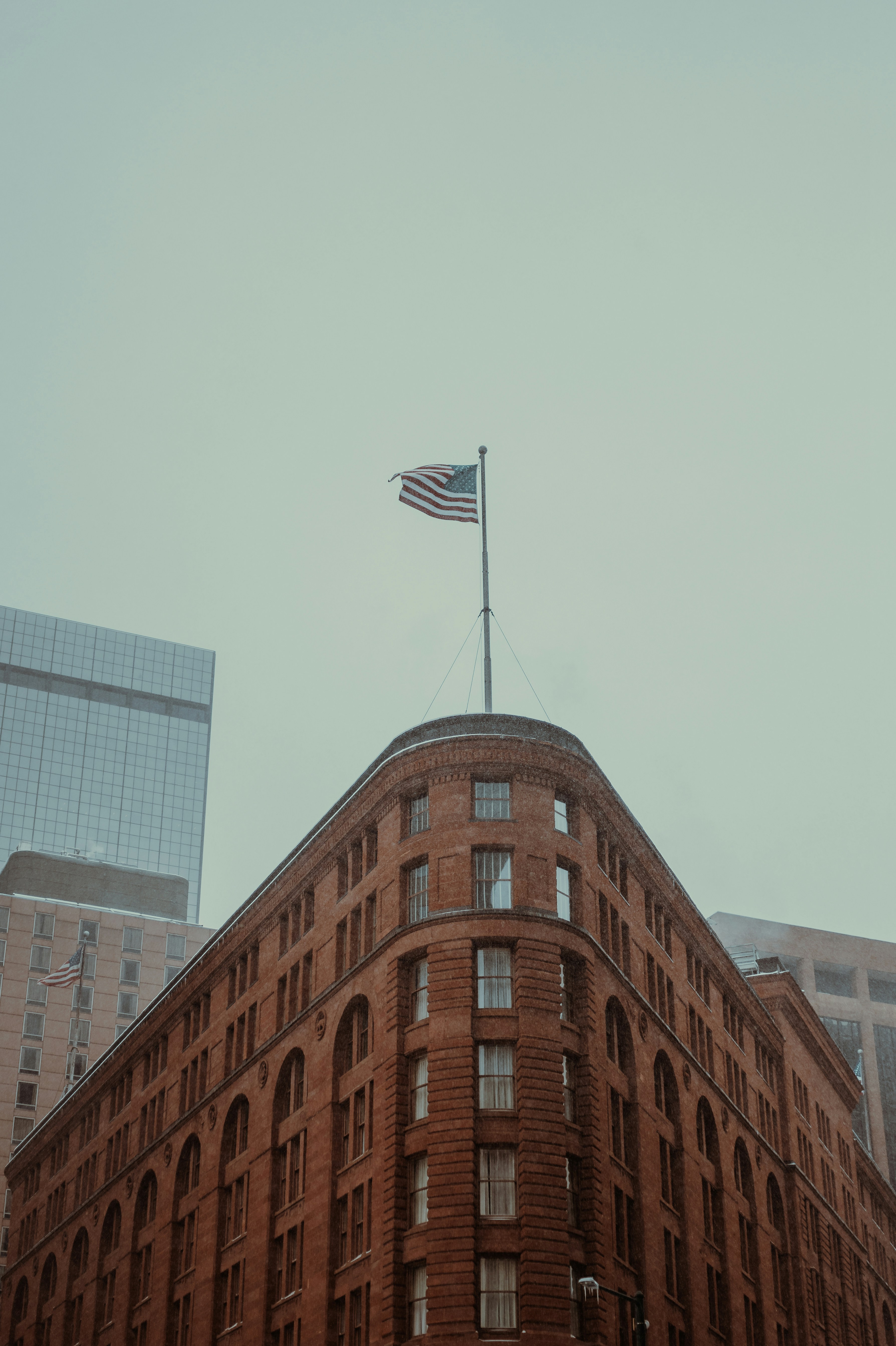 Flag over brick curve: urban classic at the crossroads of sky and stone