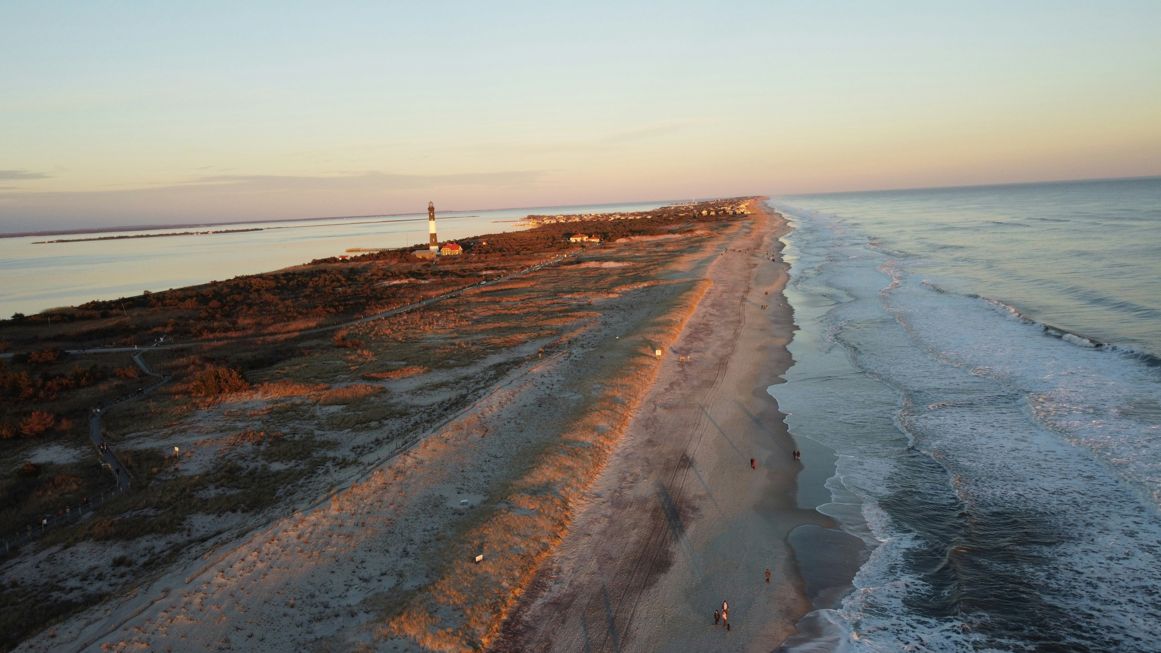 An aerial view of a beach with a lighthouse in the distance photo ...
